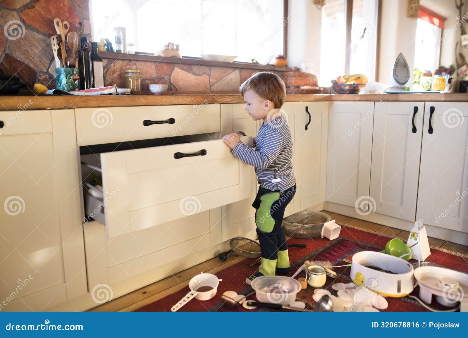 Little Boy is Taking Kitchen Utensils Out of the Drawers, Making a Mess ...