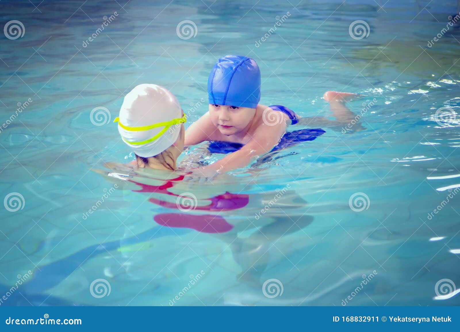 Little Boy Using the Kickboard for Learning To Swim with Trainer in the ...