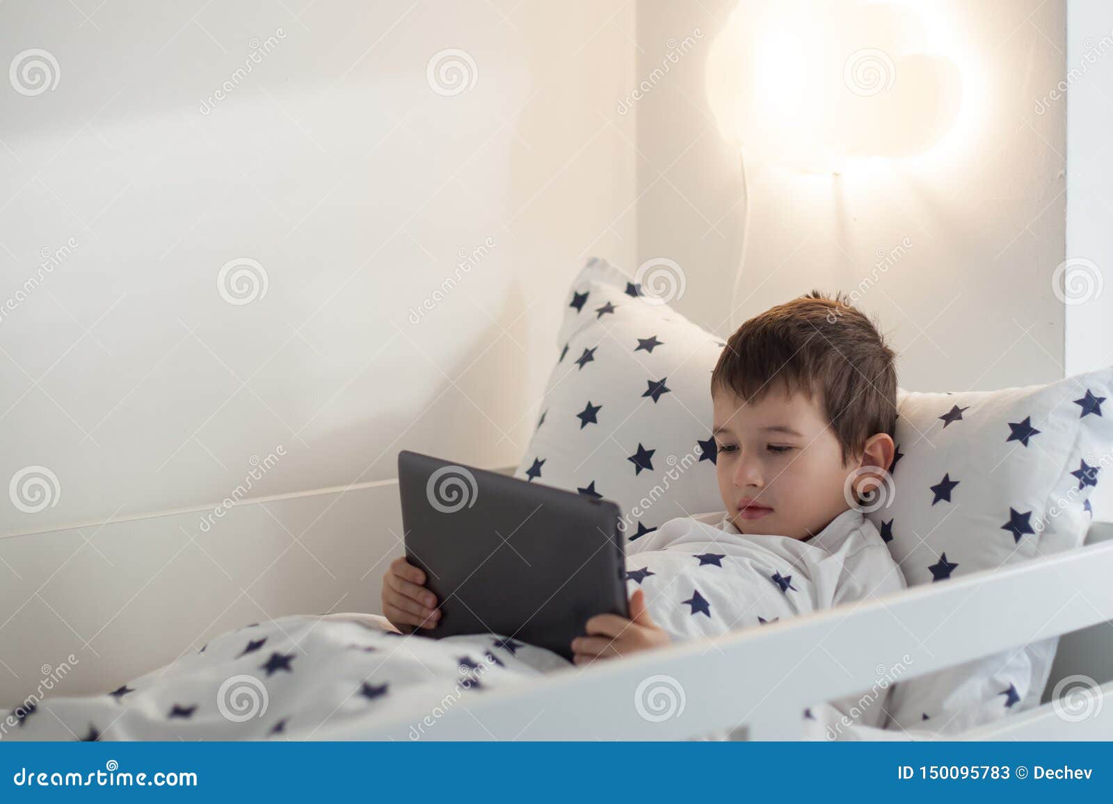 Little Boy Watching Digital Tablet Lying on Bed. Child with Technology ...