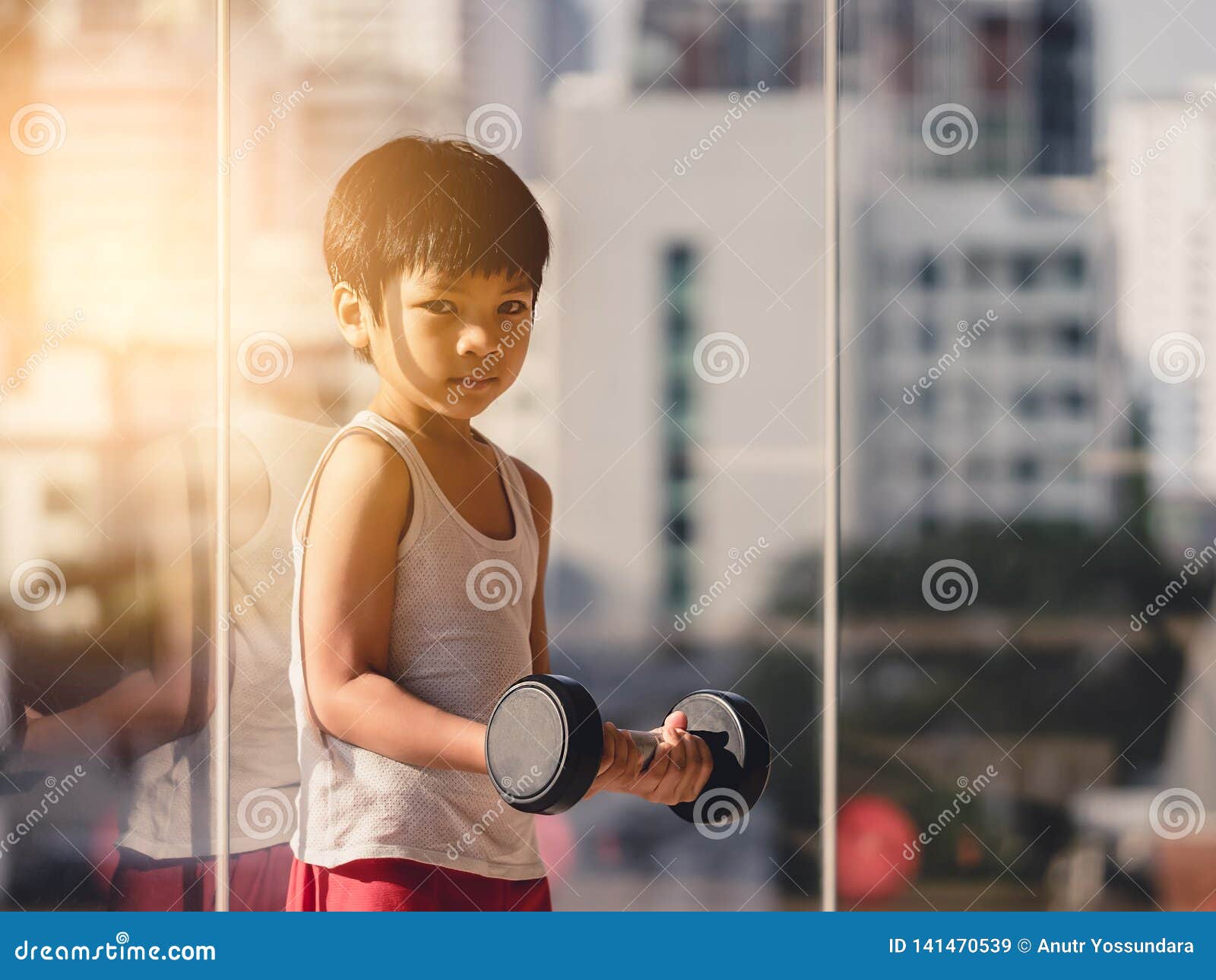 Boy is Working Out with Dumbbell by the Windows City Stock Image ...