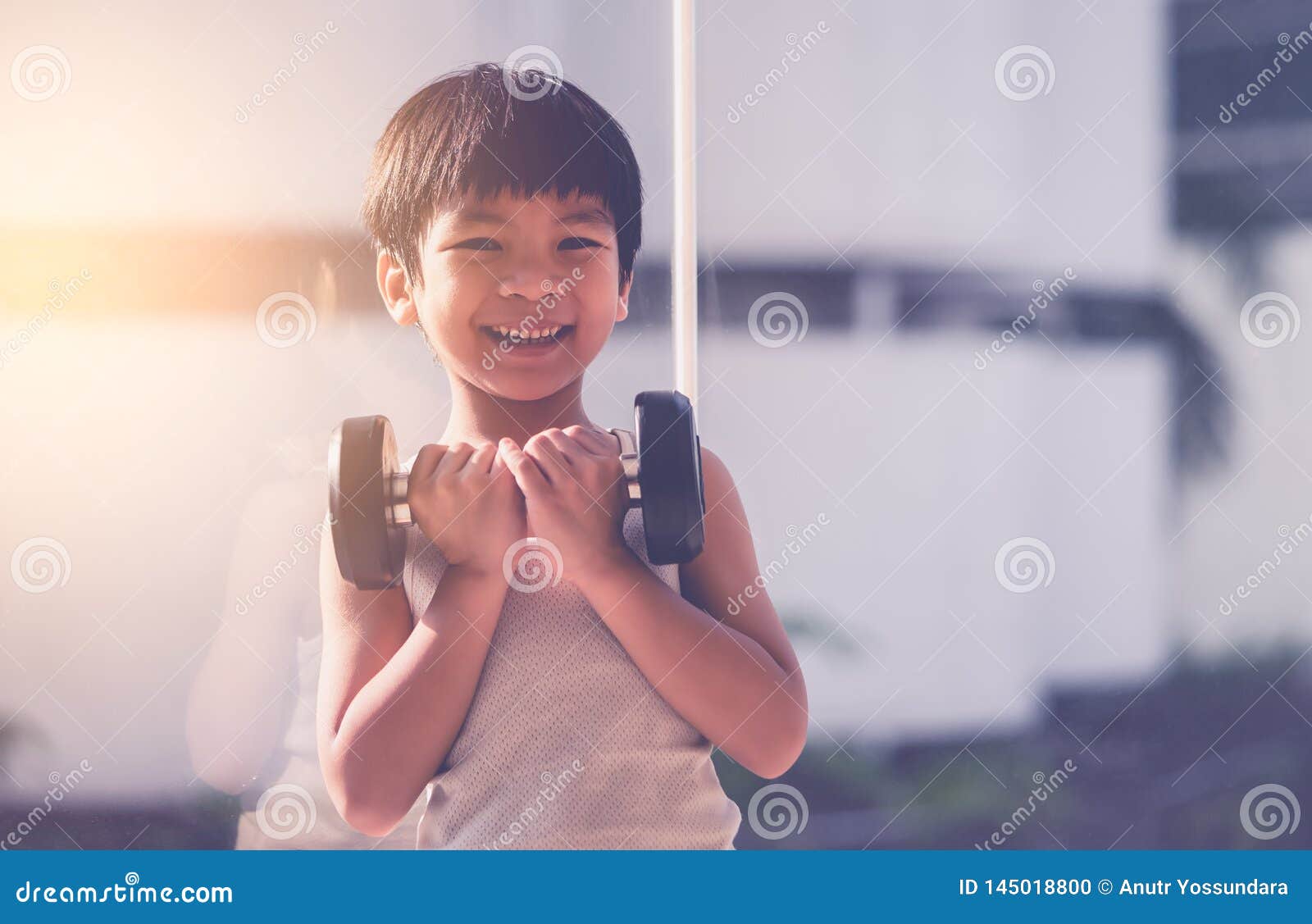Boy is Working Out with Dumbbell by the Windows City Stock Photo ...