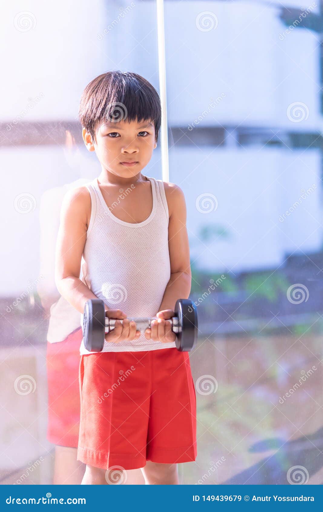 Boy is Working Out with Dumbbell by the Windows City Stock Image ...