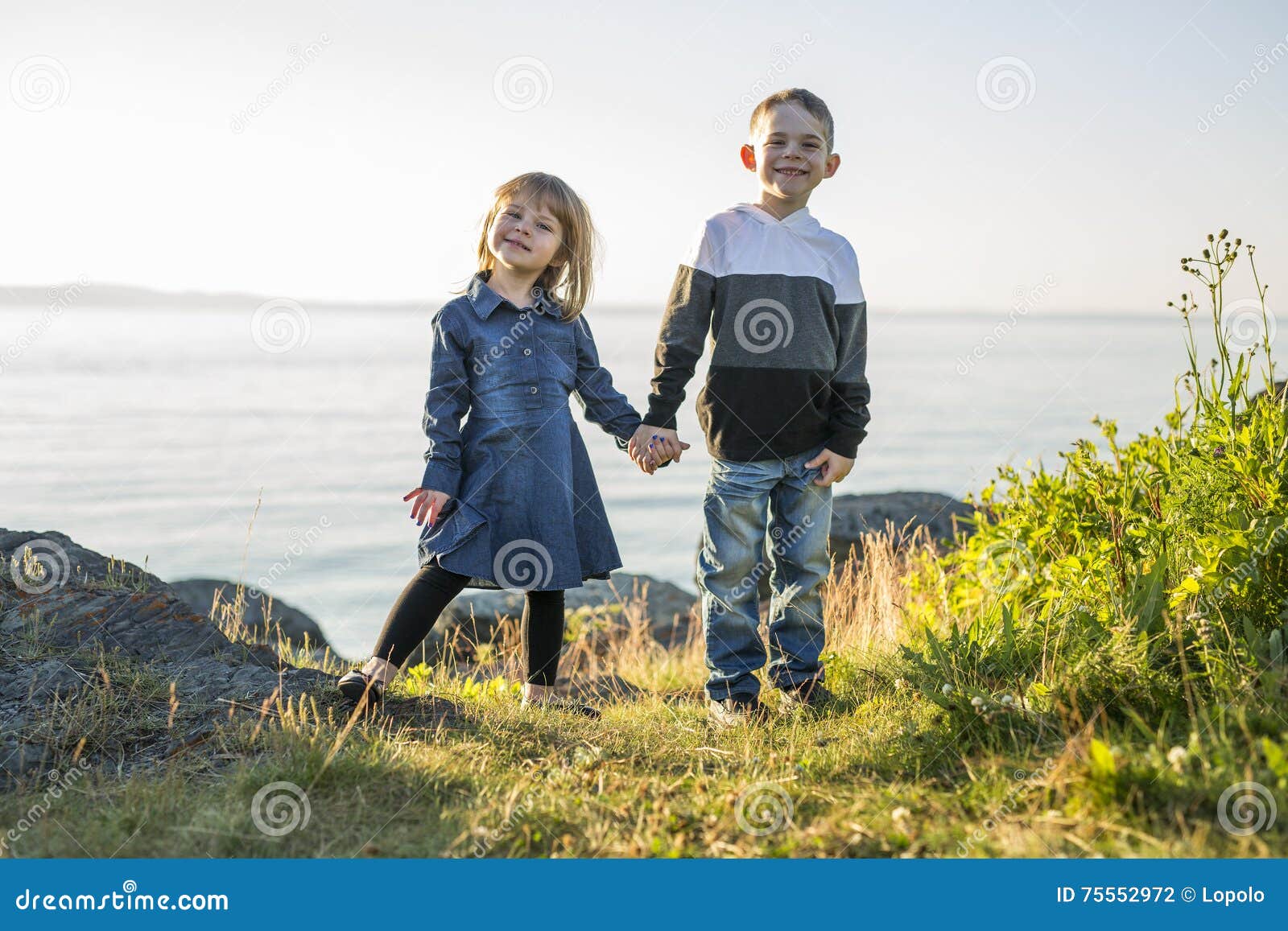 Little Brother and Sister Playing in the Grass on Sunset in Summer ...