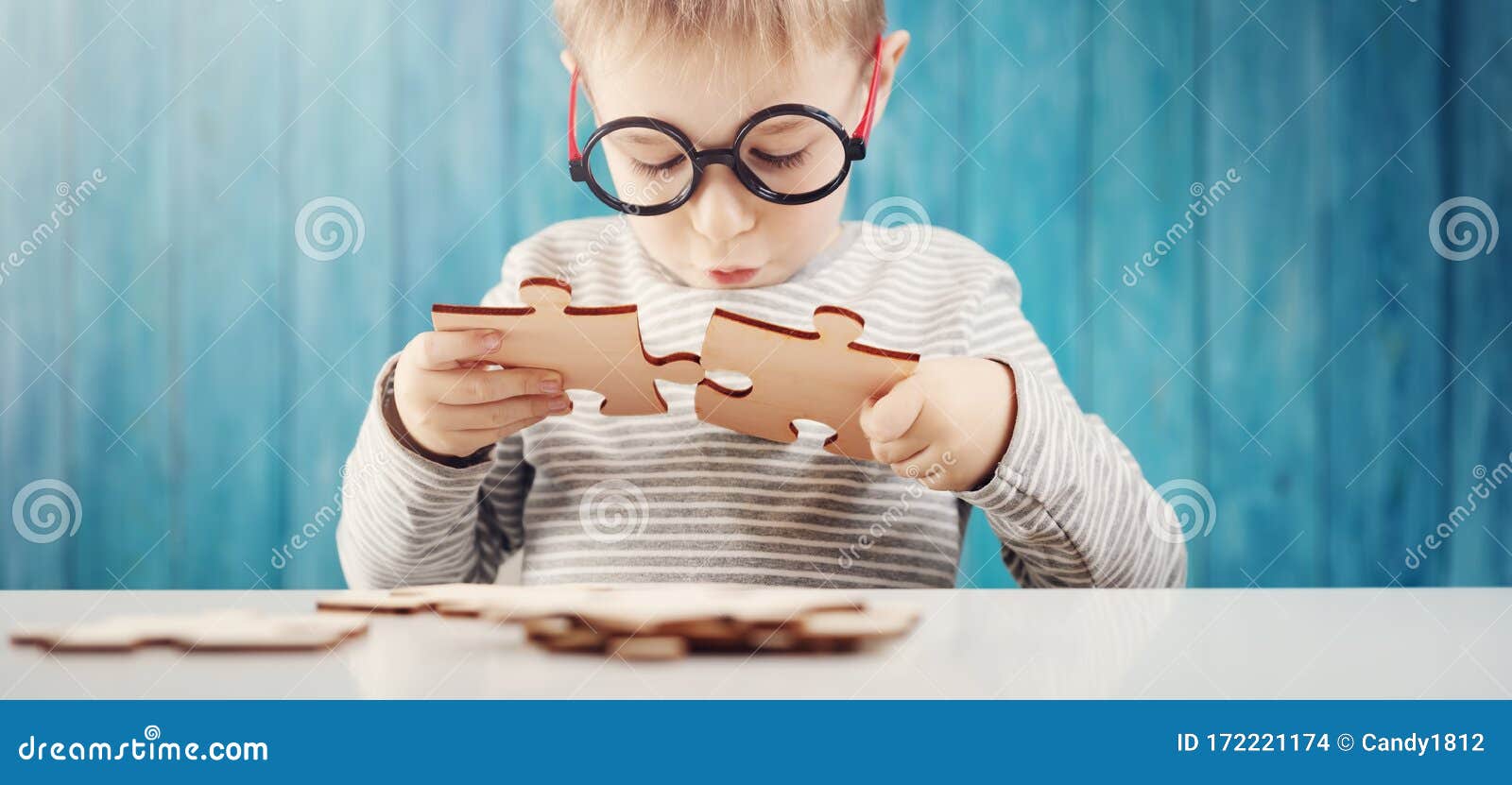 Little Child Holding Puzzle Pieces and Trying To Solve it Stock Photo ...