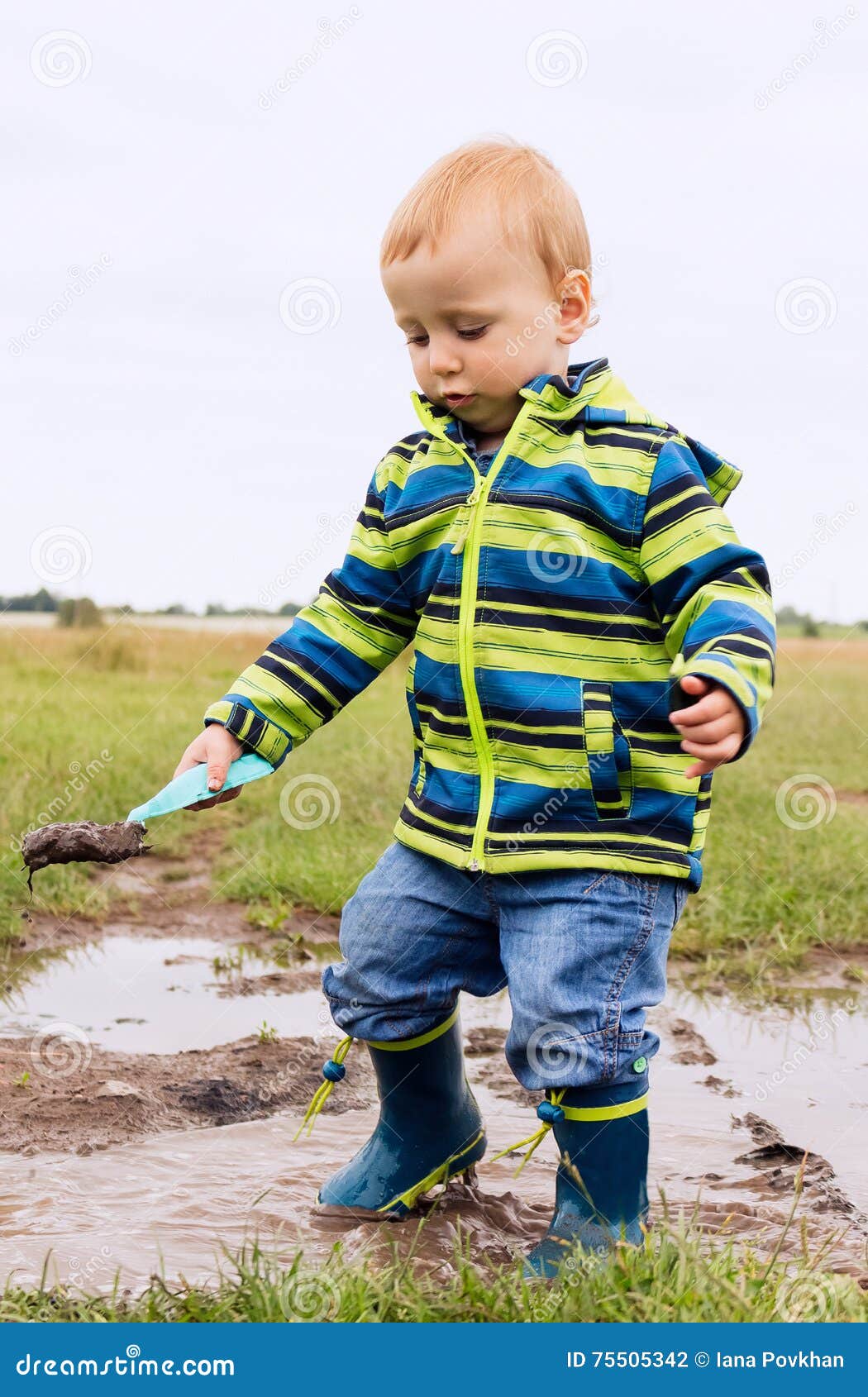 A Little Child is Playing in a Muddy Puddle Stock Photo - Image of ...