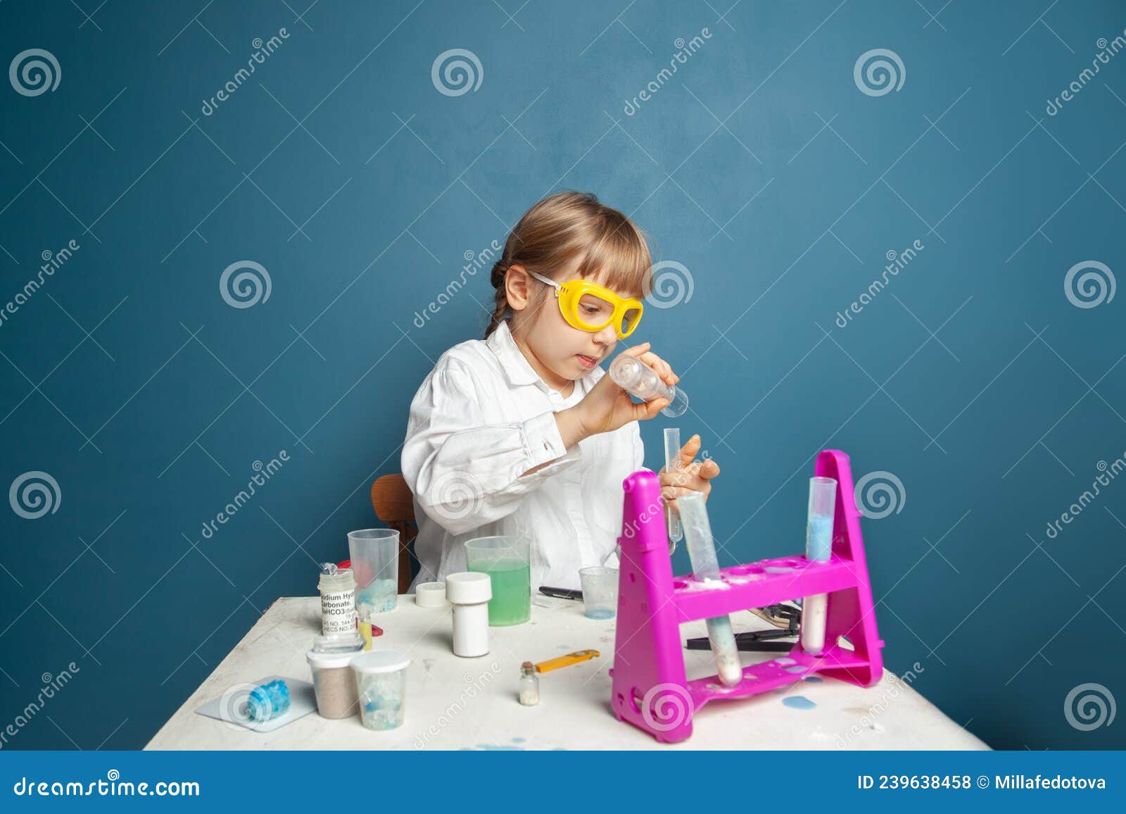 Little Child is Wearing Uniform and Glasses while Practising Science ...