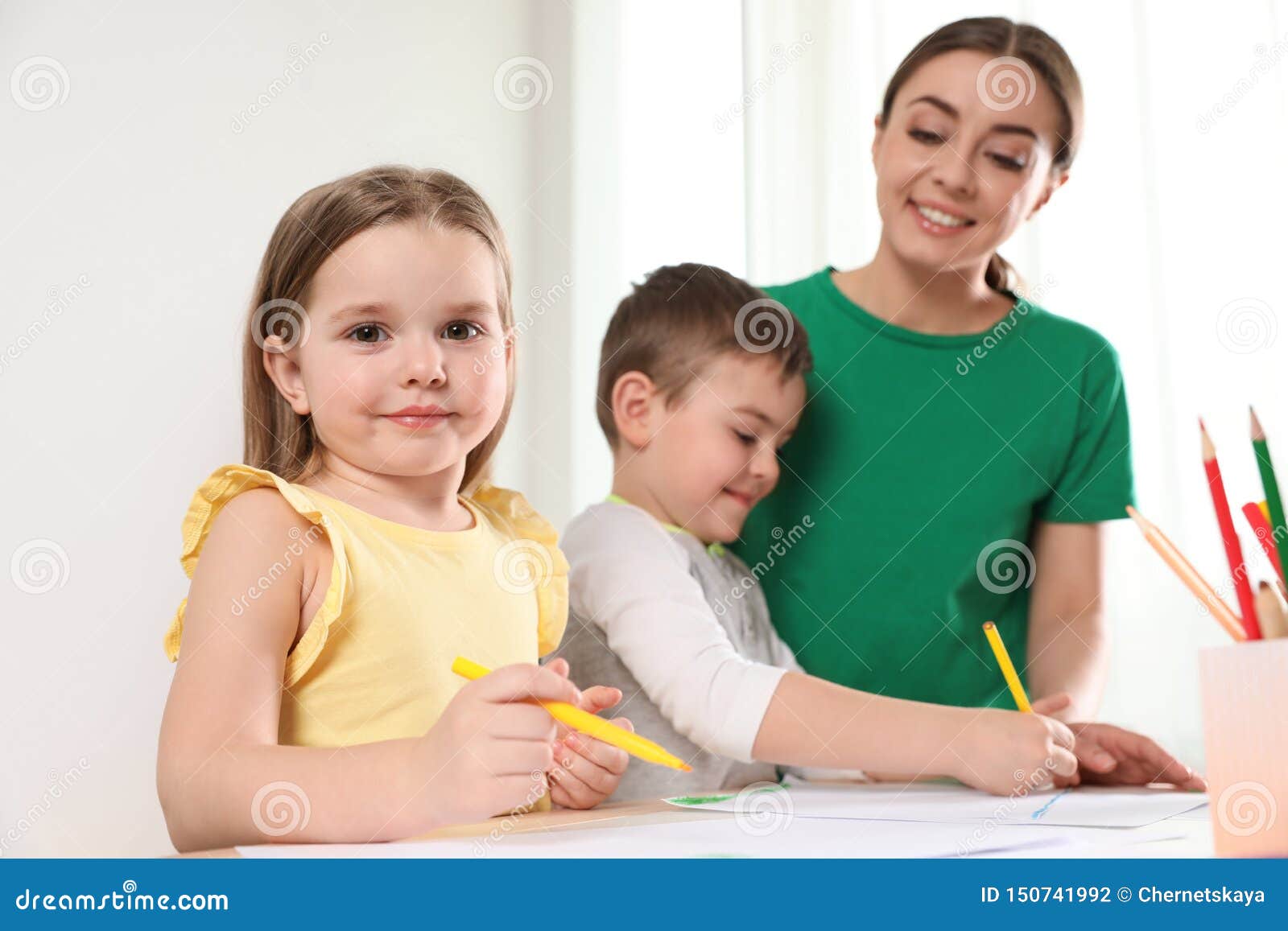 Little Children with Kindergarten Teacher Drawing at Table Indoors ...