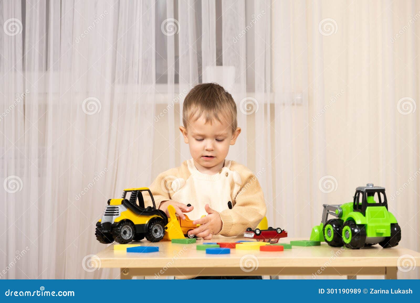 Little Cute Boy Playing with Toys while Sitting at Table Stock Image ...