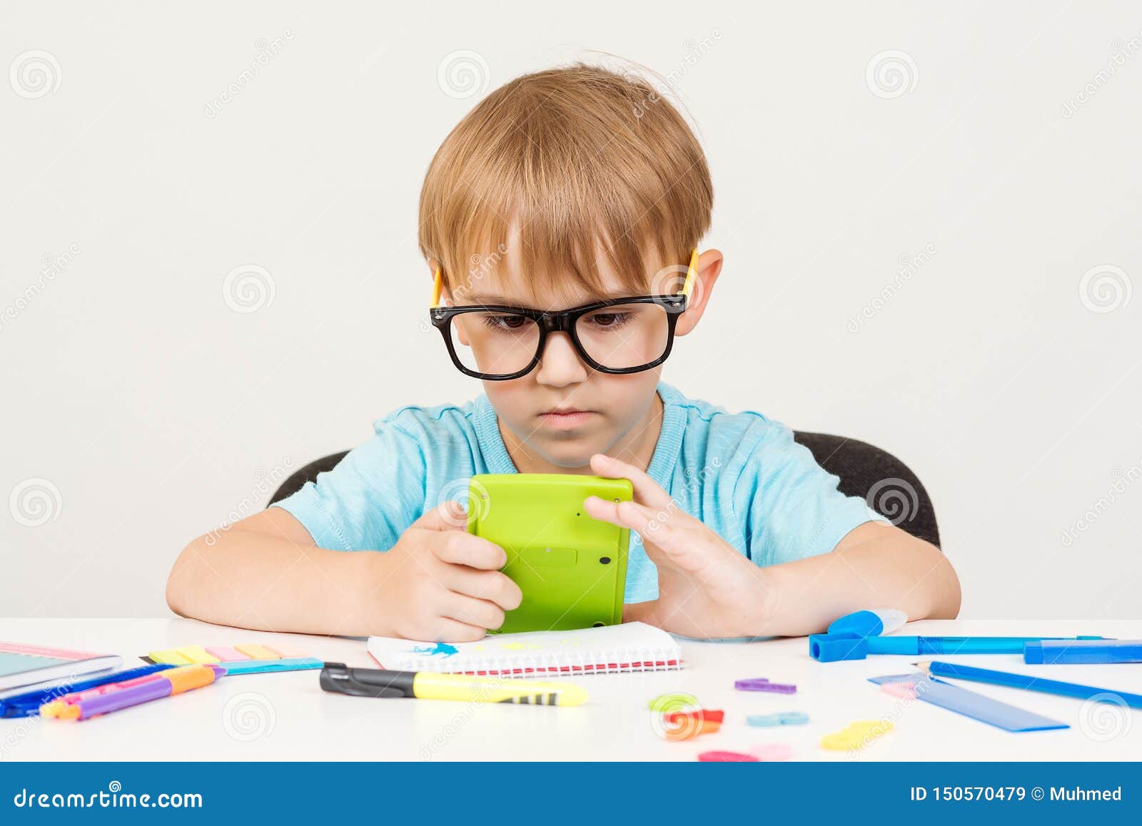 Little Cute Boy Sits at Table and Counts Something with Calculator. Kid ...