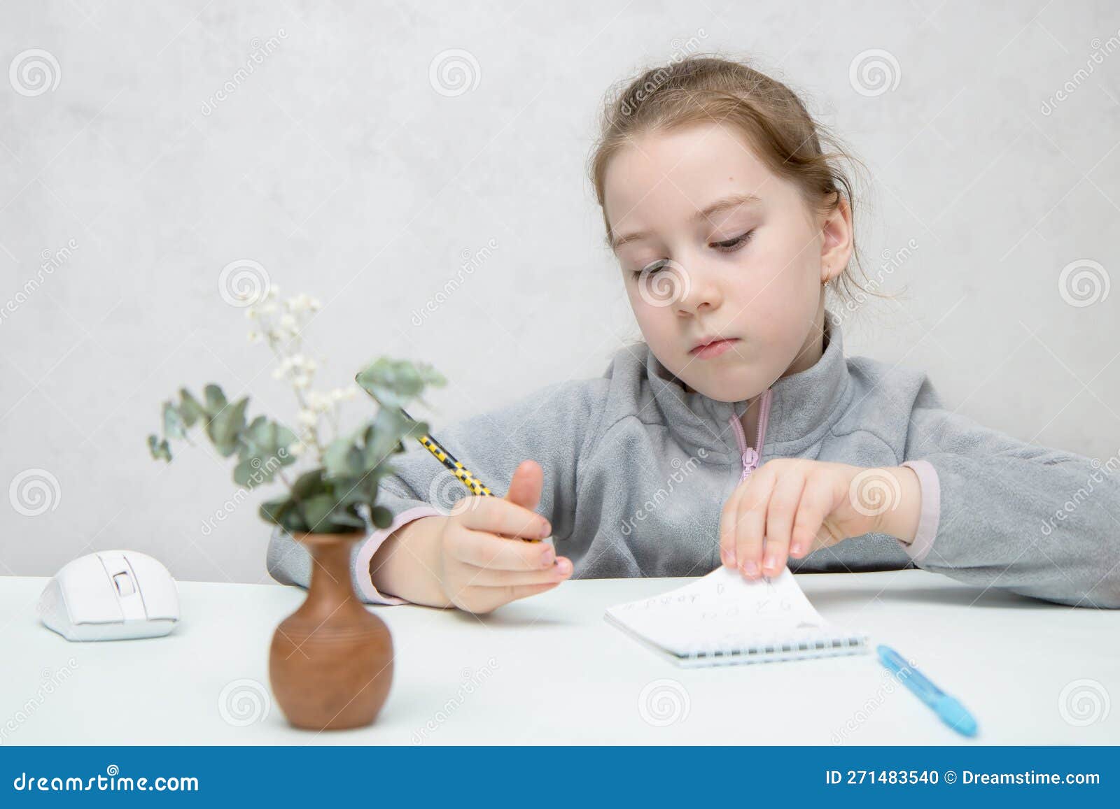 Little Cute Girl Writes Intently in a Notebook at the Table Stock Photo ...
