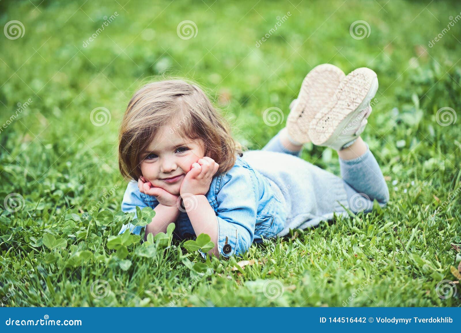 Little girl rest on grass stock photo. Image of field - 144516442