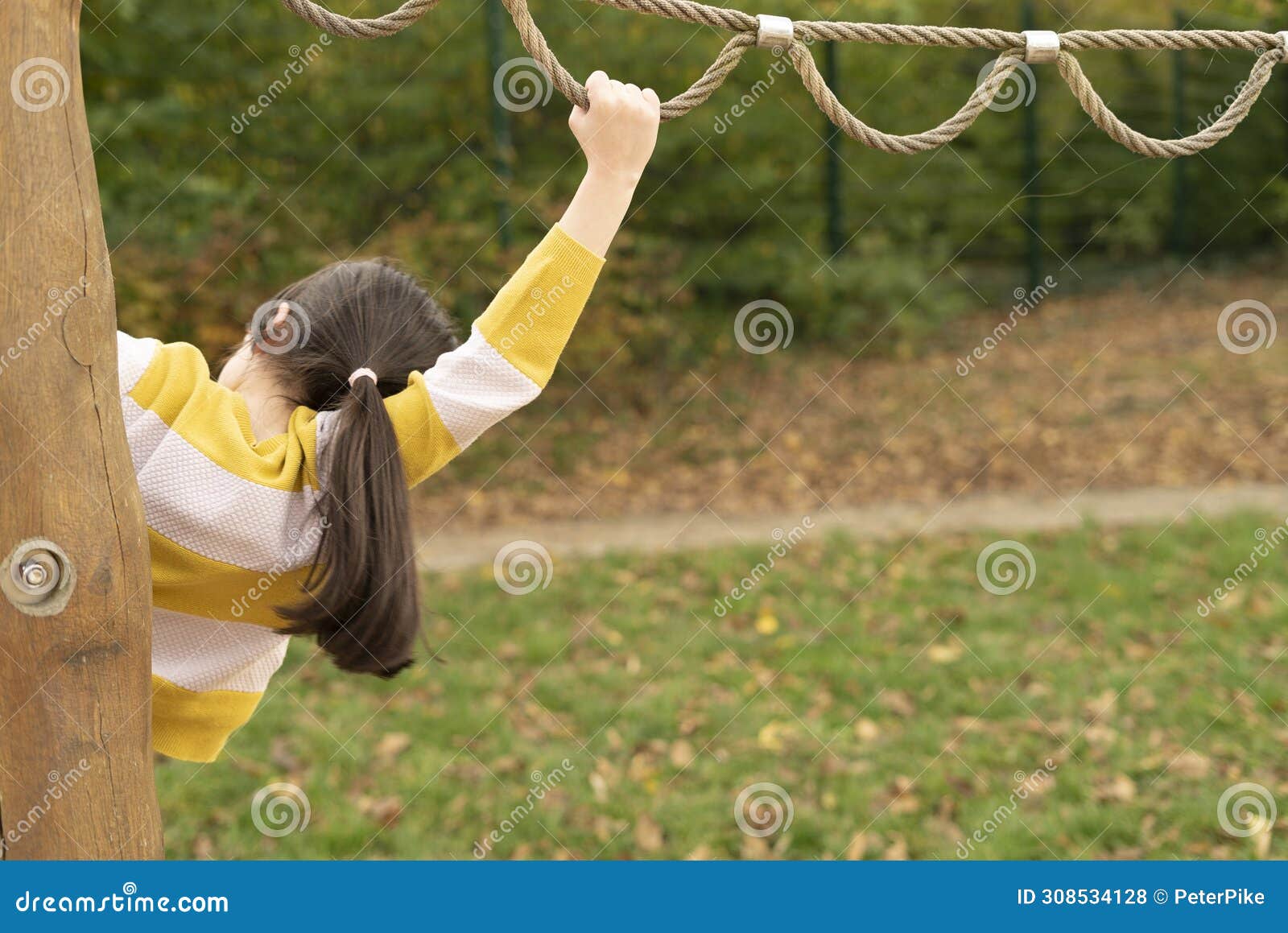 Little Girl Climbing on a Rope in a Park. Back View Stock Photo - Image ...