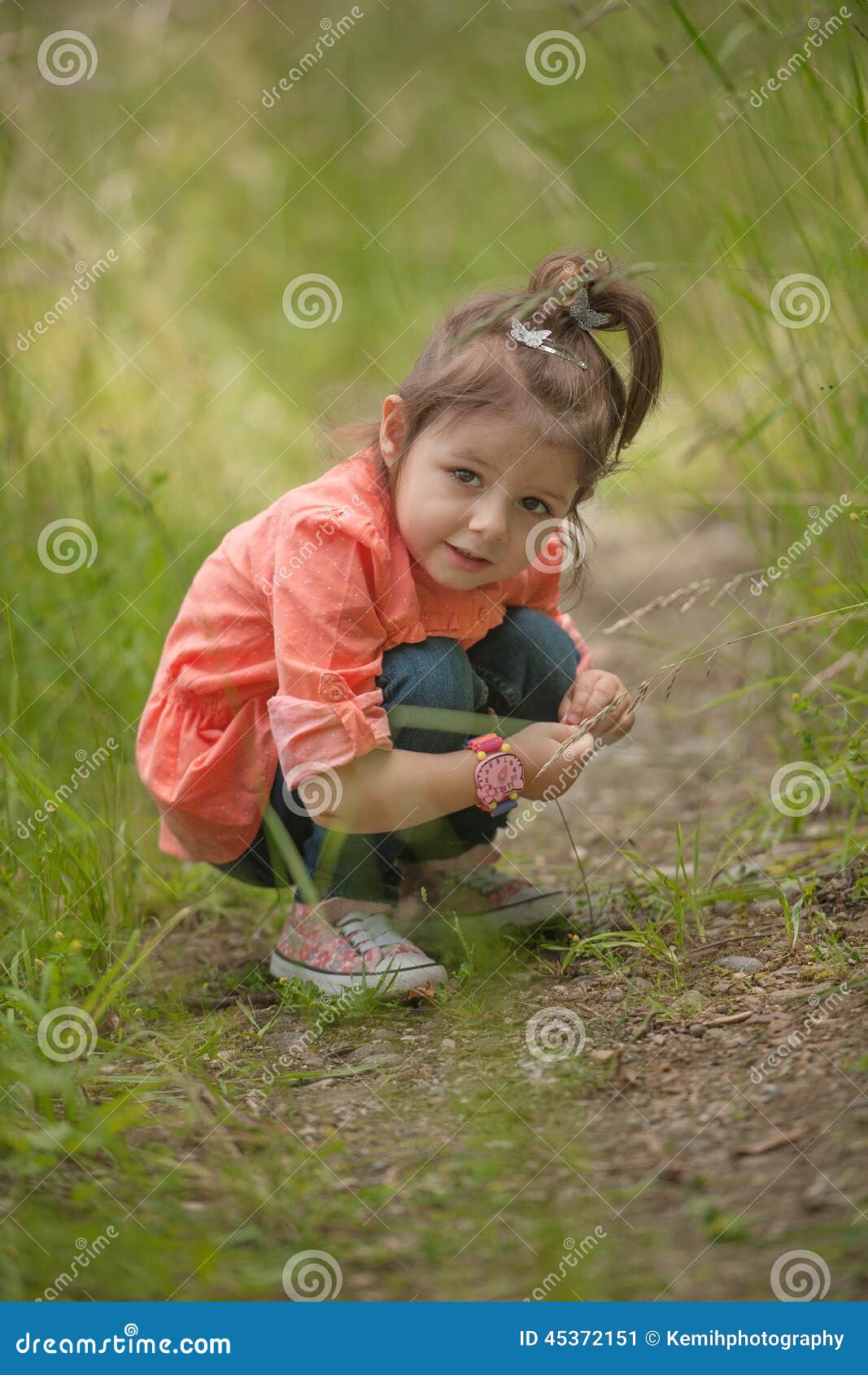 Little Girl Crouched in the Grass in the Park Stock Image - Image of ...