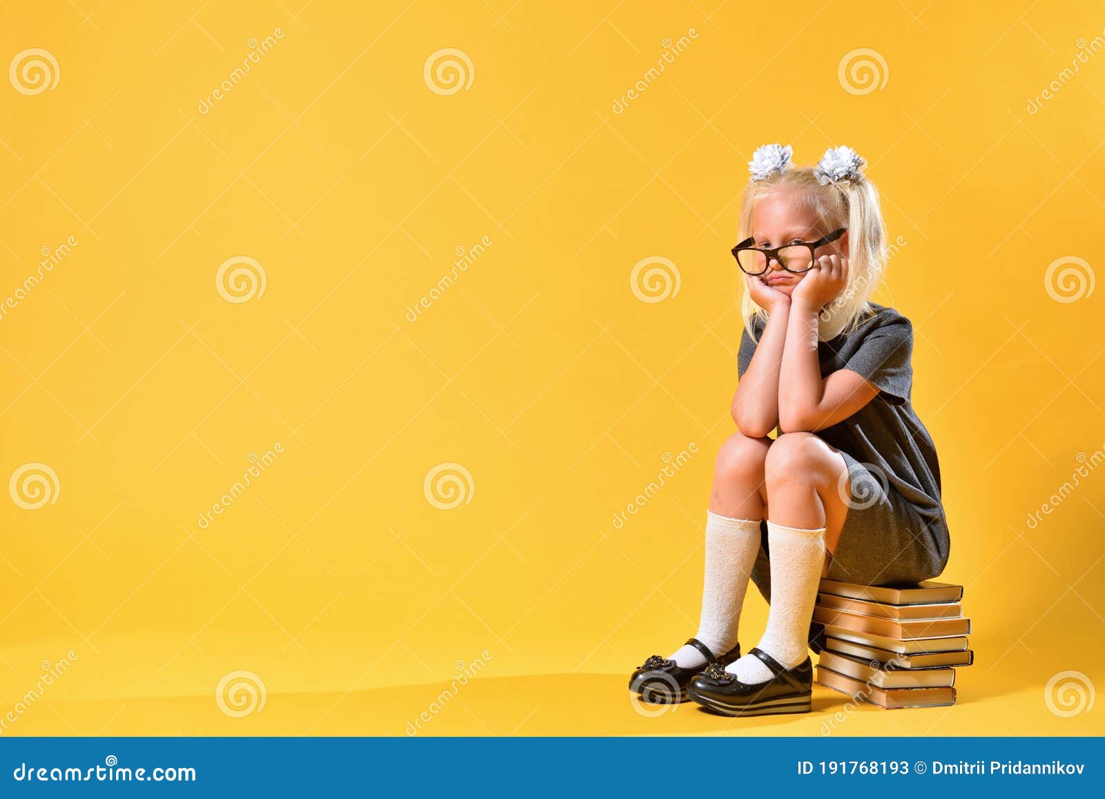Little Girl Does Not Want To Study and Sits Sad on a Stack of Books ...