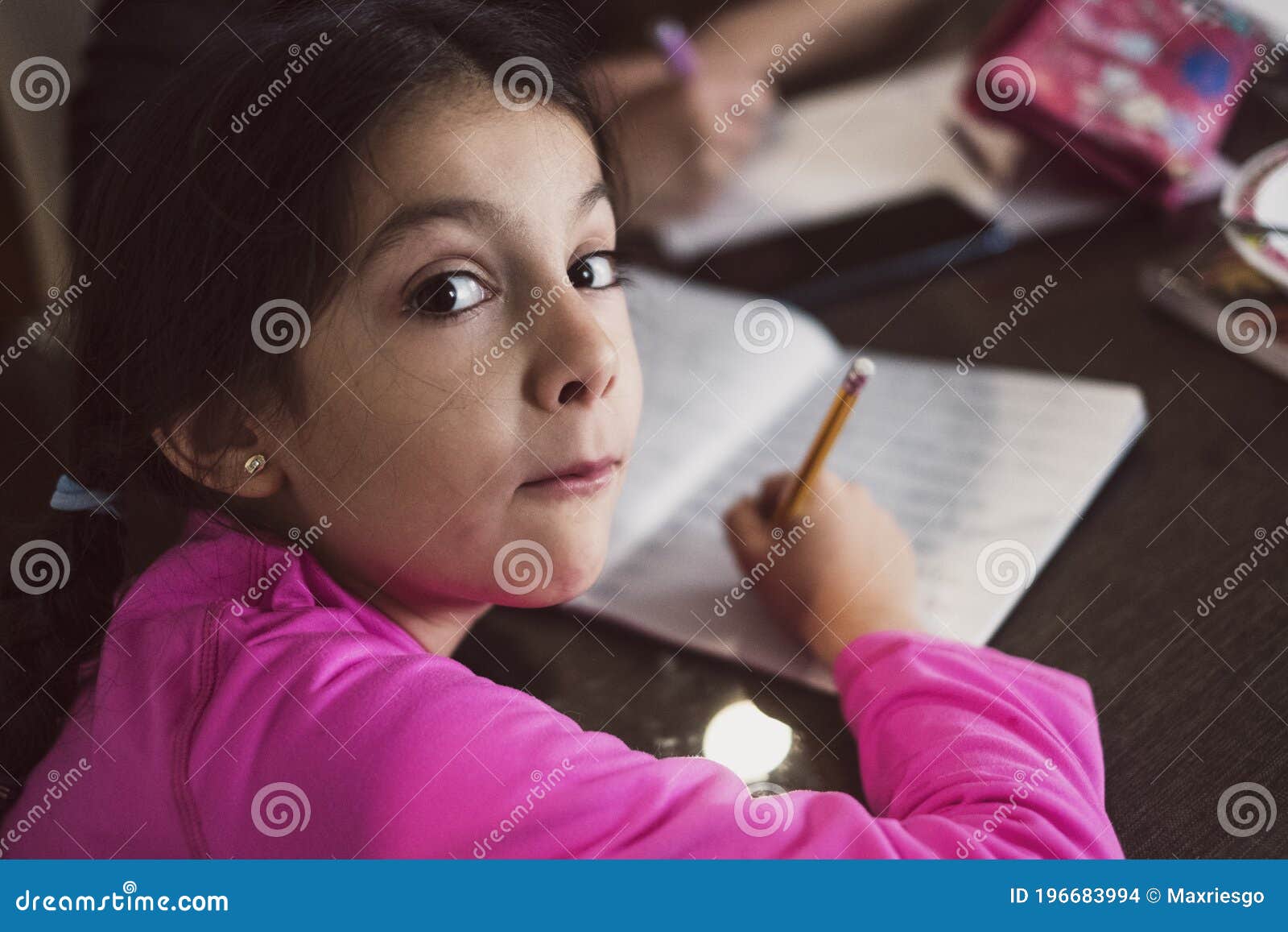 Little Girl Doing Homework and Looking at Camera Stock Photo - Image of ...