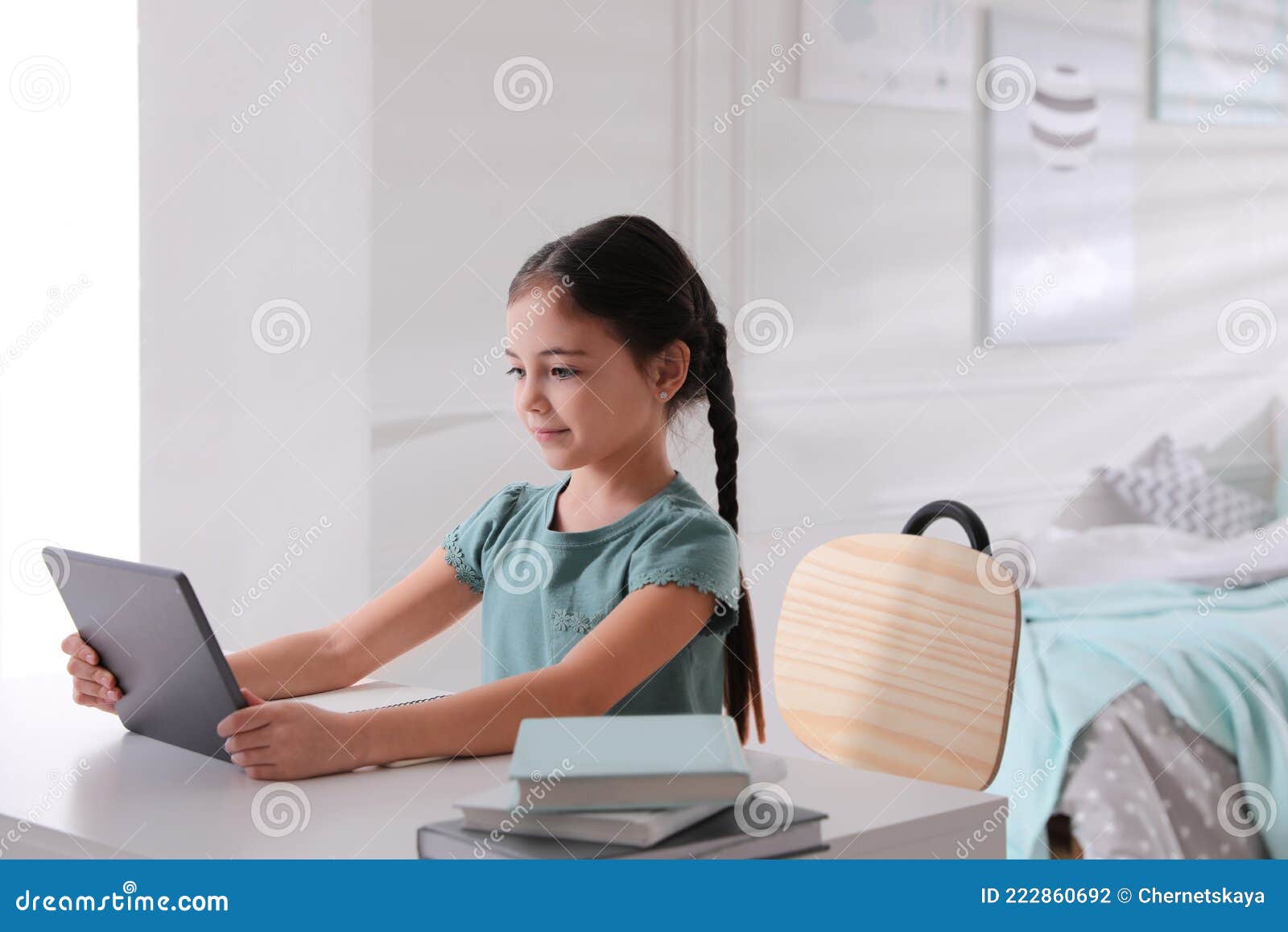 Little Girl Doing Homework with Tablet at Table in Room Stock Photo ...