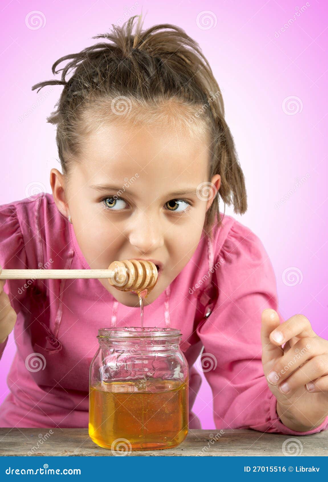 Little girl eat honey stock photo. Image of honey, face - 27015516