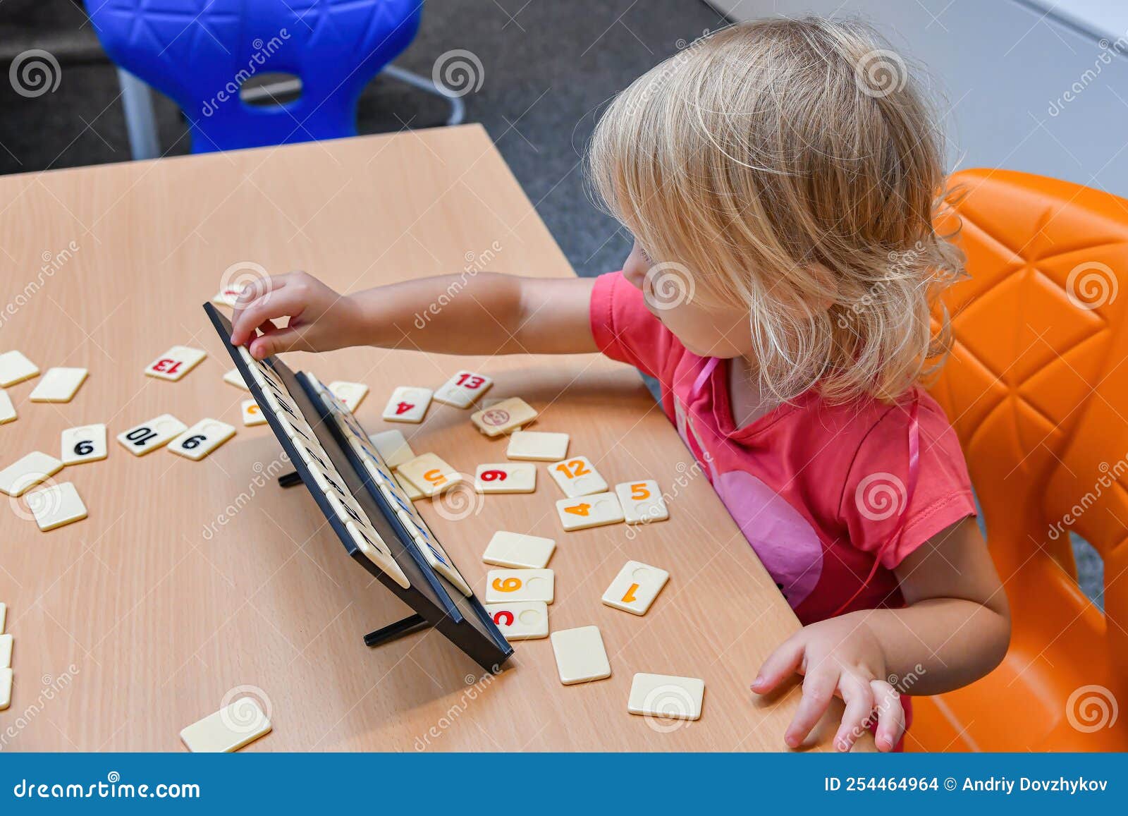 A Little Girl in Elementary School Learns Numbers and Puts Chips in ...