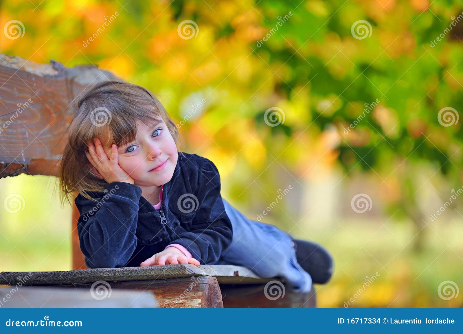 Little Girl Laying Down on a Bench Stock Photo - Image of legged ...