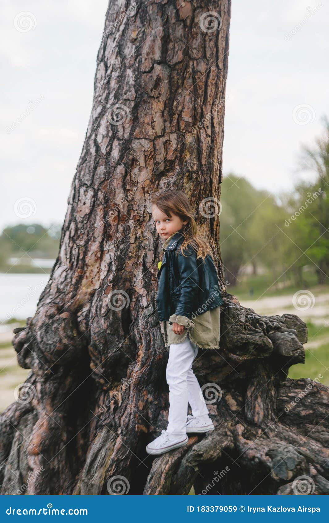 Little Girl Leaning Against a Large Oak Tree and Looking at the Camera ...