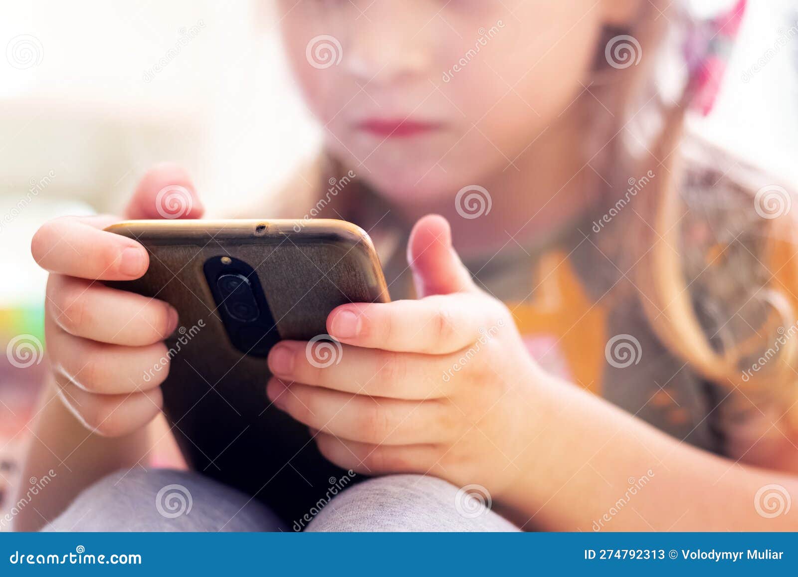 A Little Girl is Looking Intently at Her Phone. Children and Modern ... A Little Girl is Looking Intently at Her Phone. Children and Modern ...