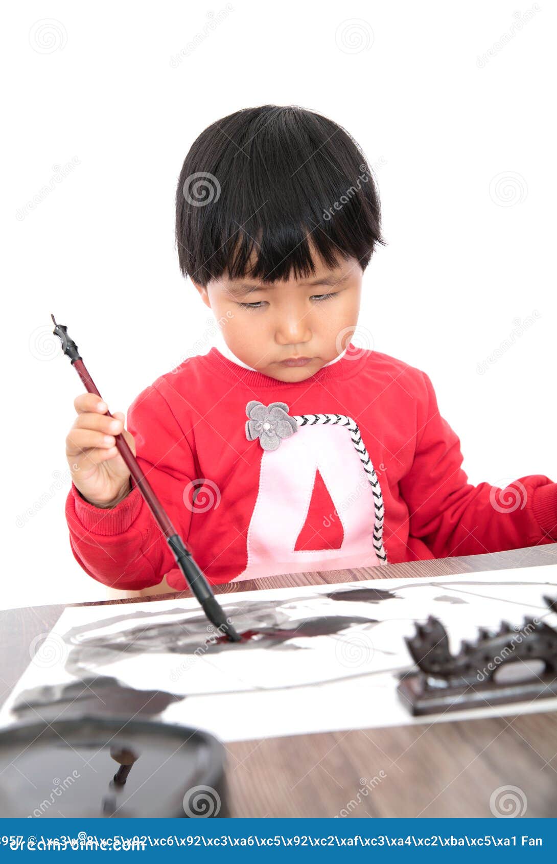 A Little Girl Practicing Calligraphy in Front of a White Background ...