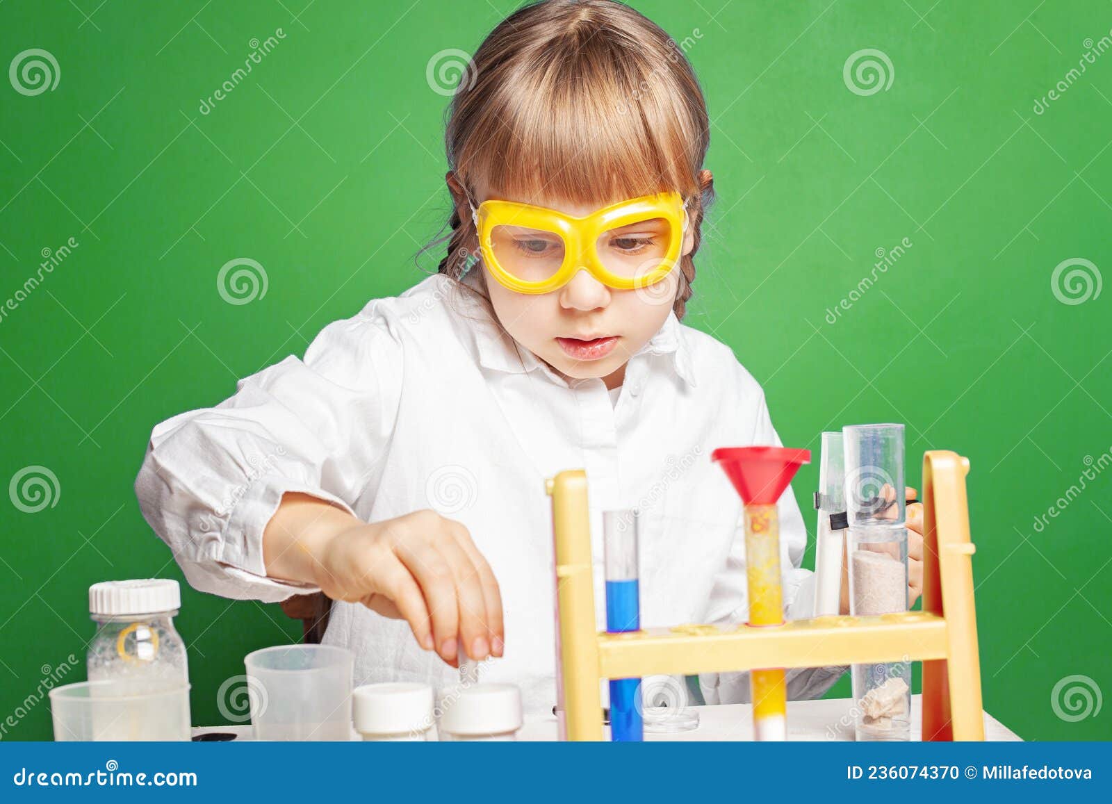 Little Girl with Science Experiments on Green Background Stock Photo ...