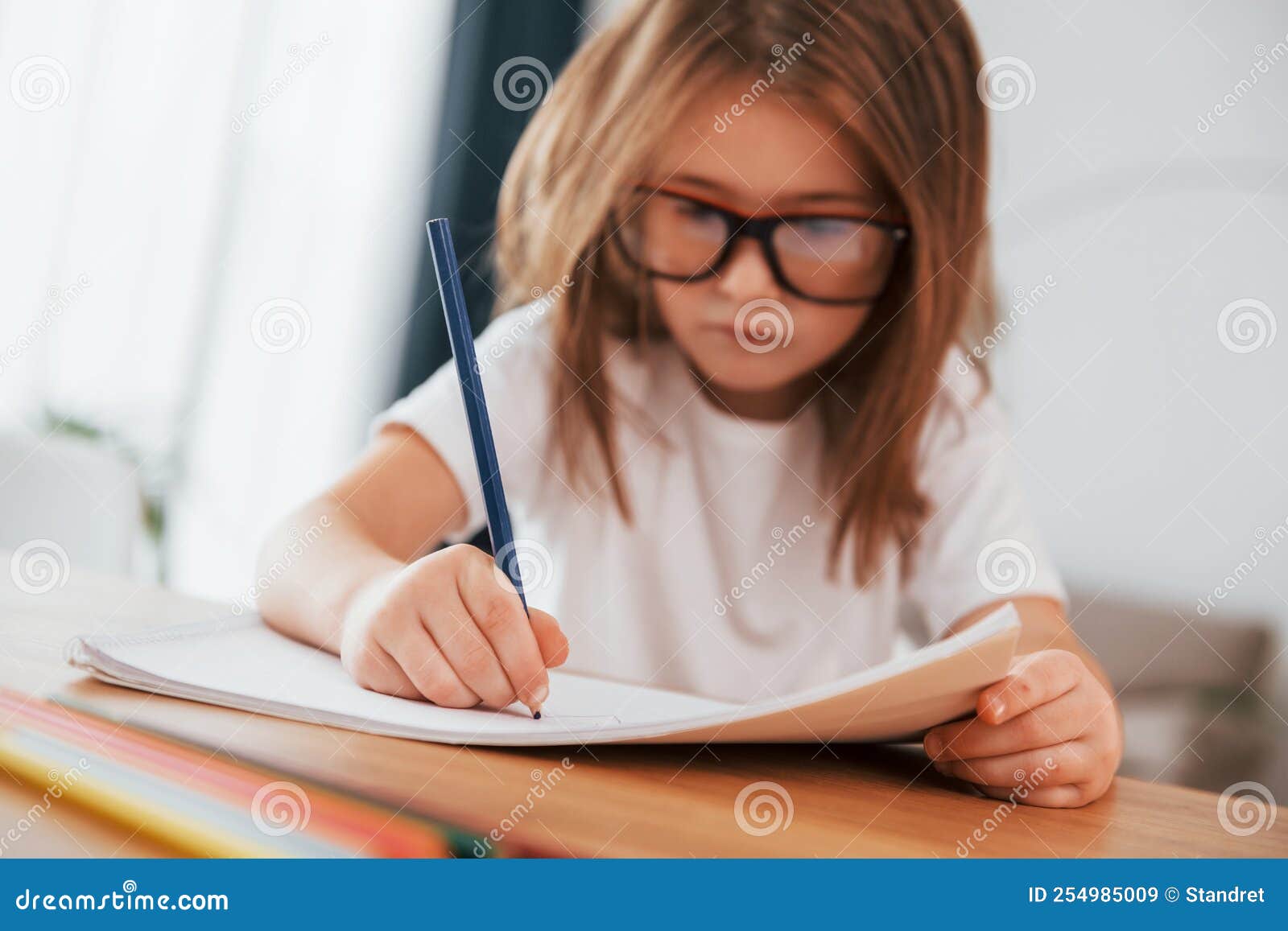 Little Girl is Sitting by the Table and Learning To Draw Stock Image ...