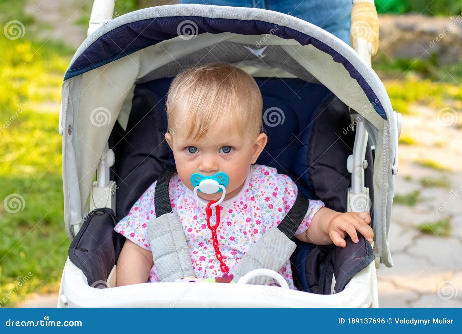 Little Girl in a Stroller with a Pacifier in Her Mouth Stock Photo ...