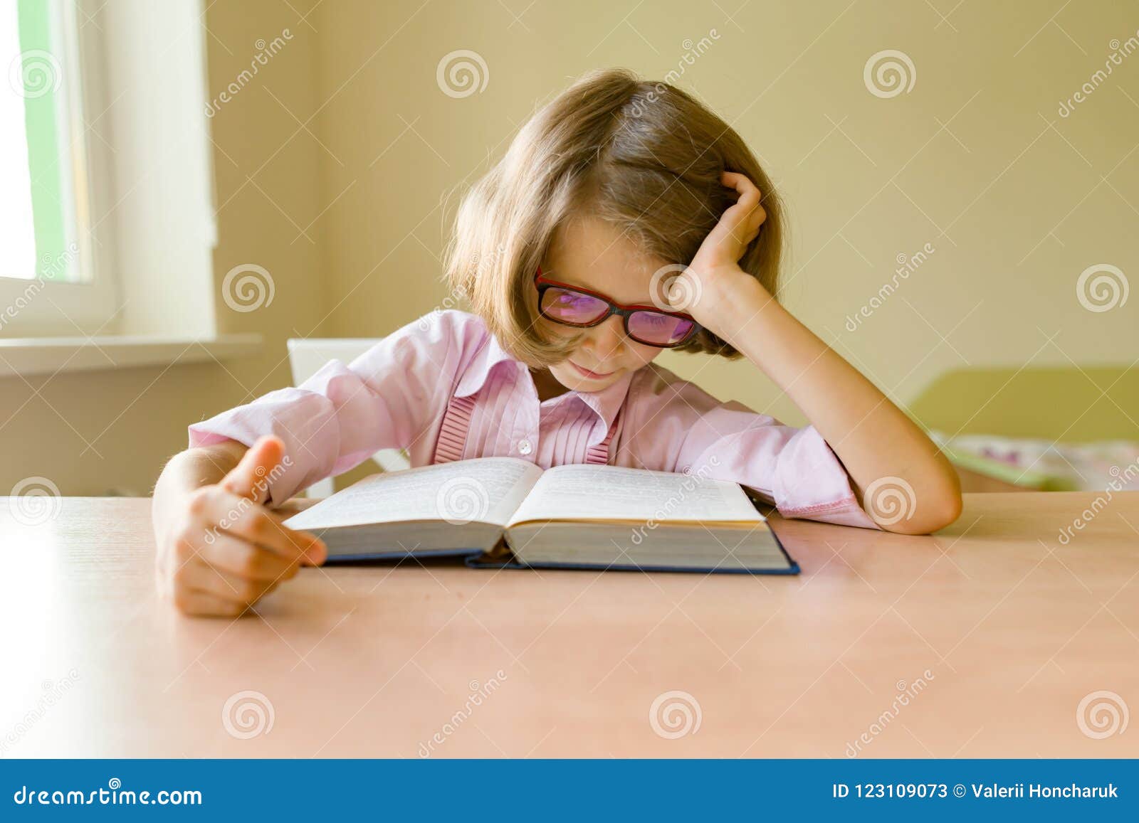 Little Girl Student Sits at a Desk with Book. School, Education ... Little Girl Student Sits at a Desk with Book. School, Education ...