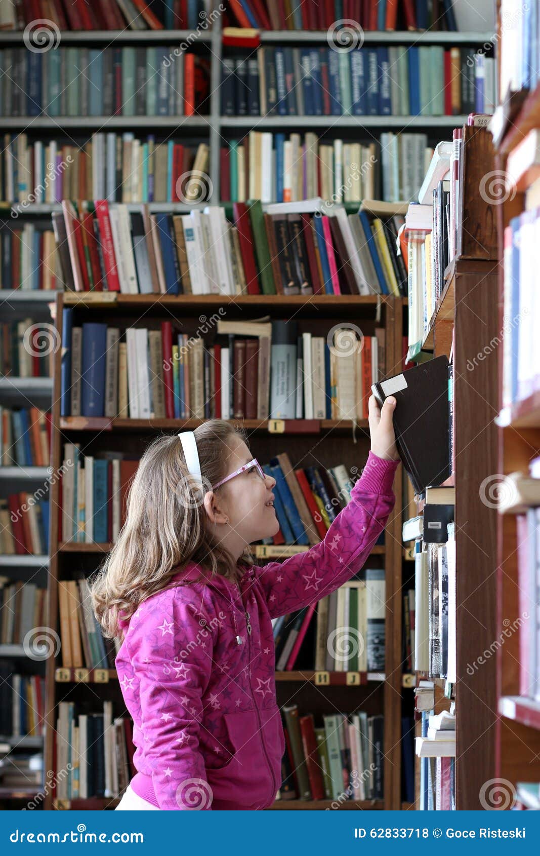 Little girl taking a book stock photo. Image of books - 62833718