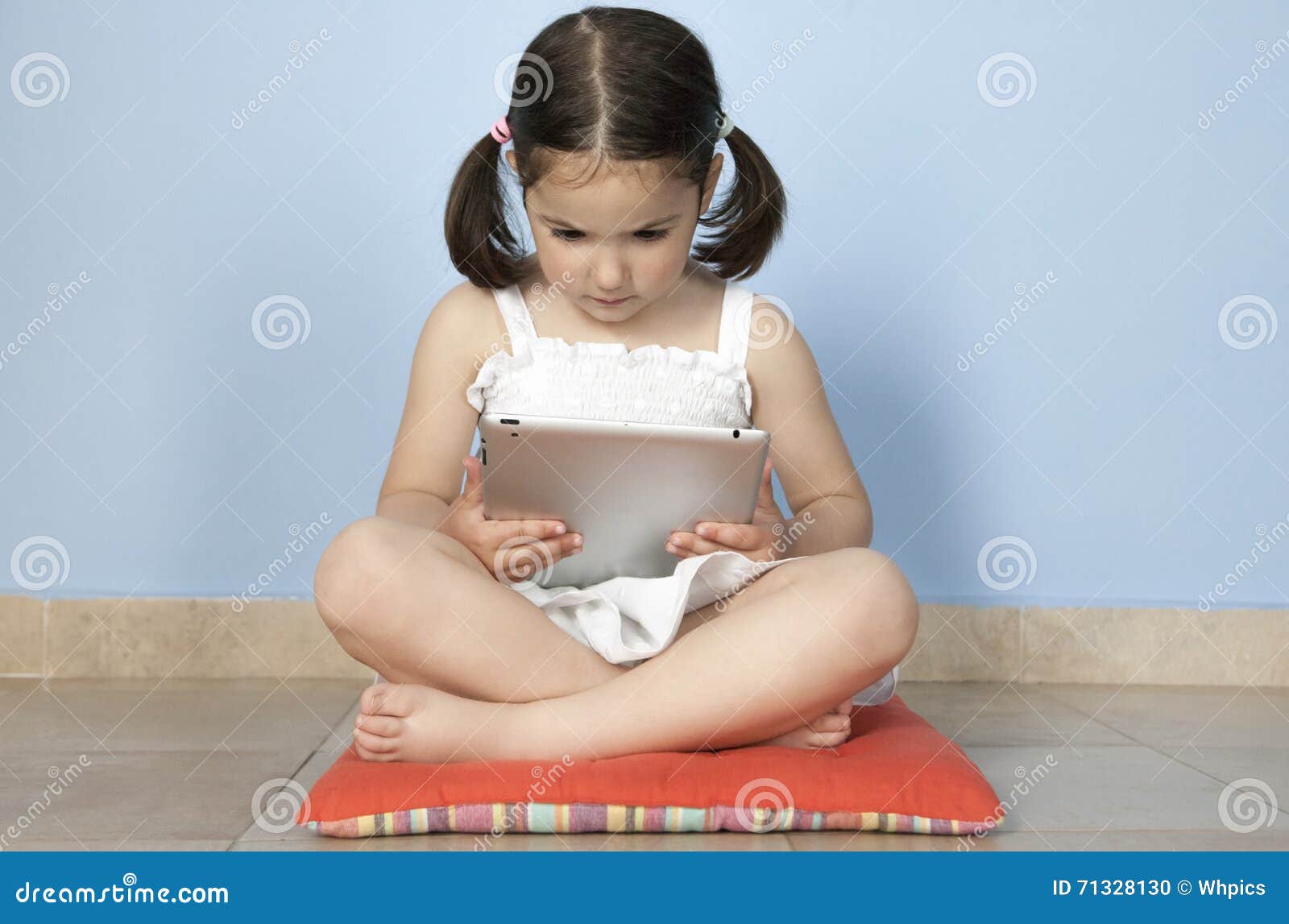 Little Girl Using Tablet Computer Stock Photo - Image of cushion, blue ...