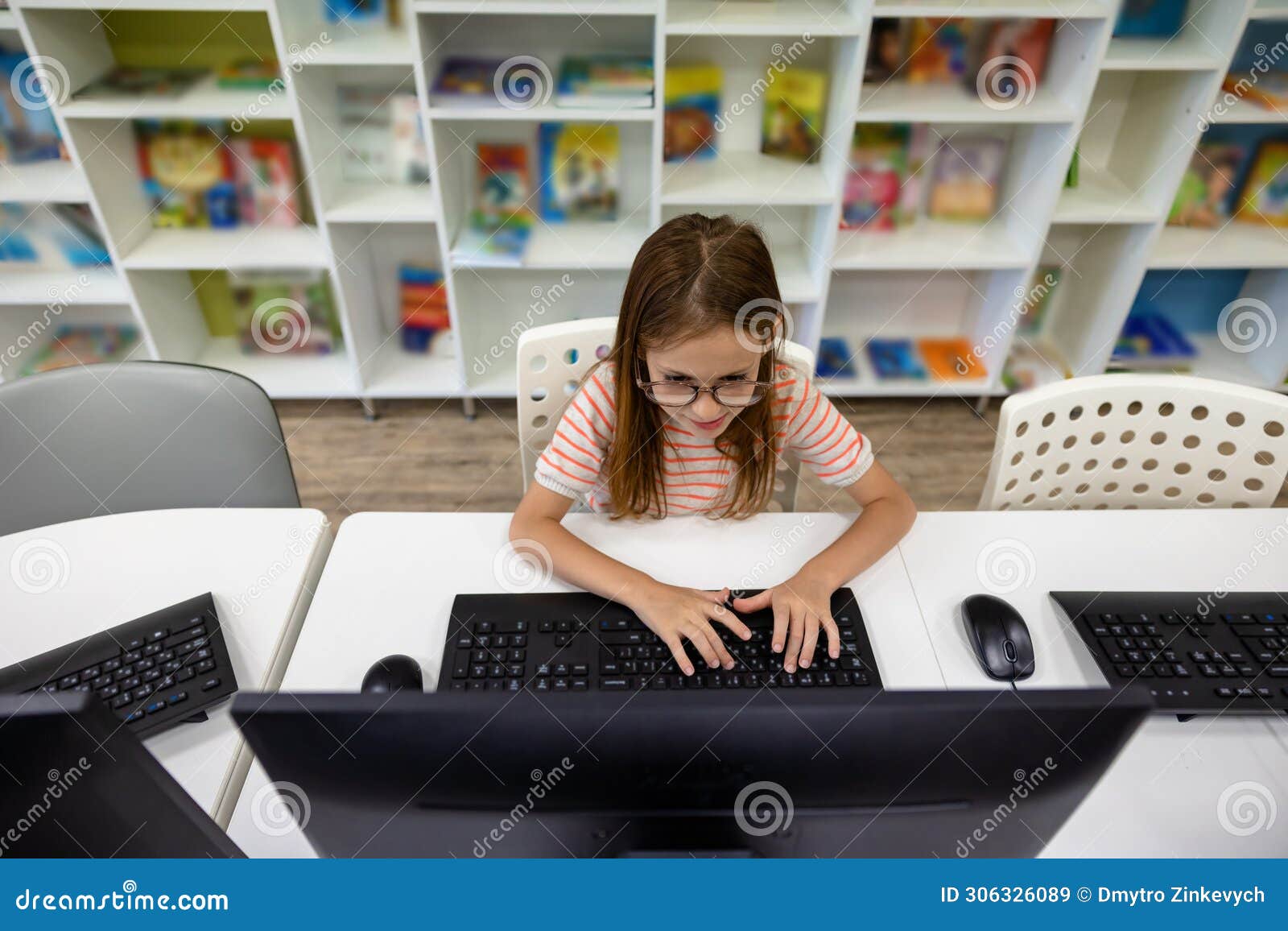 Little Girl Working on Computer in School Library. Stock Image - Image ...