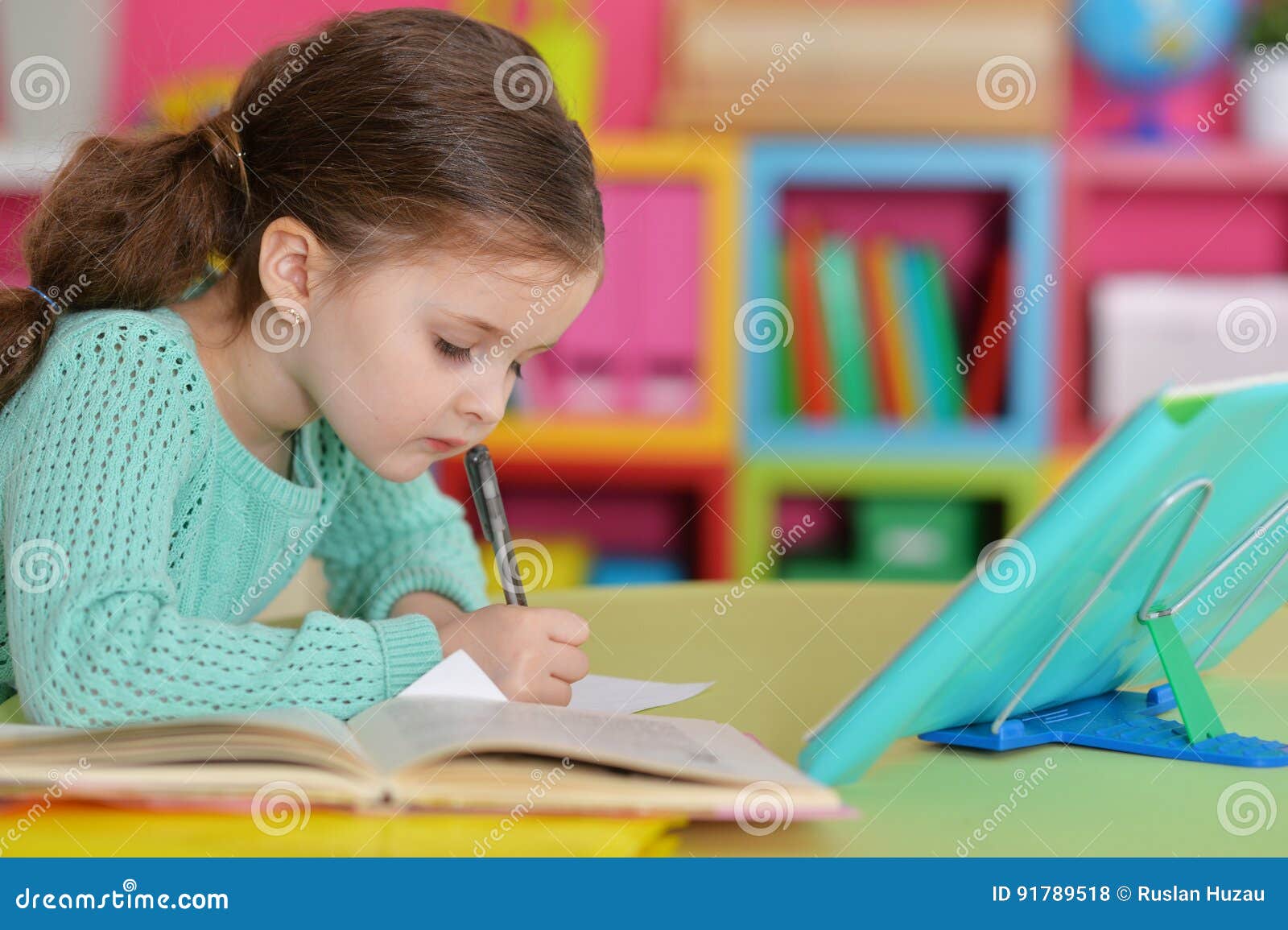 Little Girl Writing while Sitting at Table Stock Photo - Image of ...