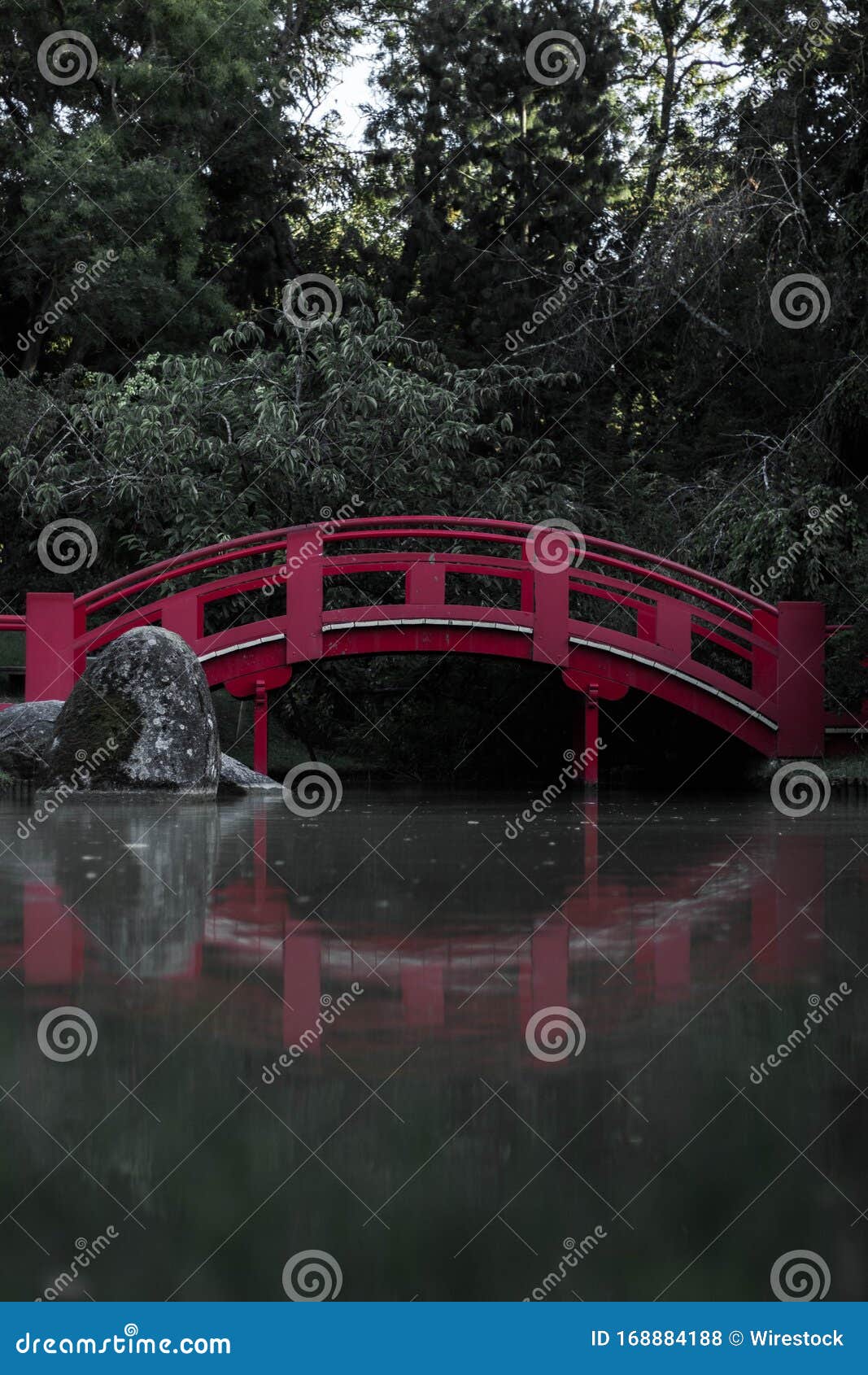 Little Red Bridge Reflecting on the Water in a Forest Covered in ...