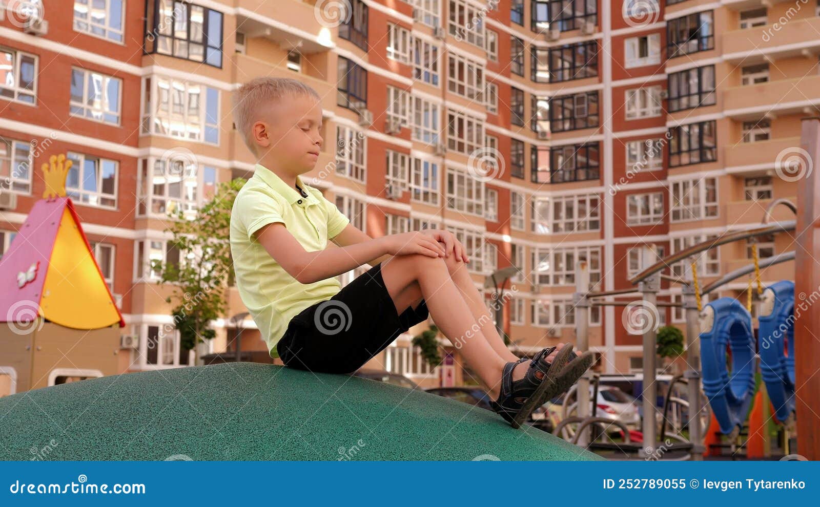 A Little Sad Boy Sits on a Smooth Artificial Stone in a Modern ...