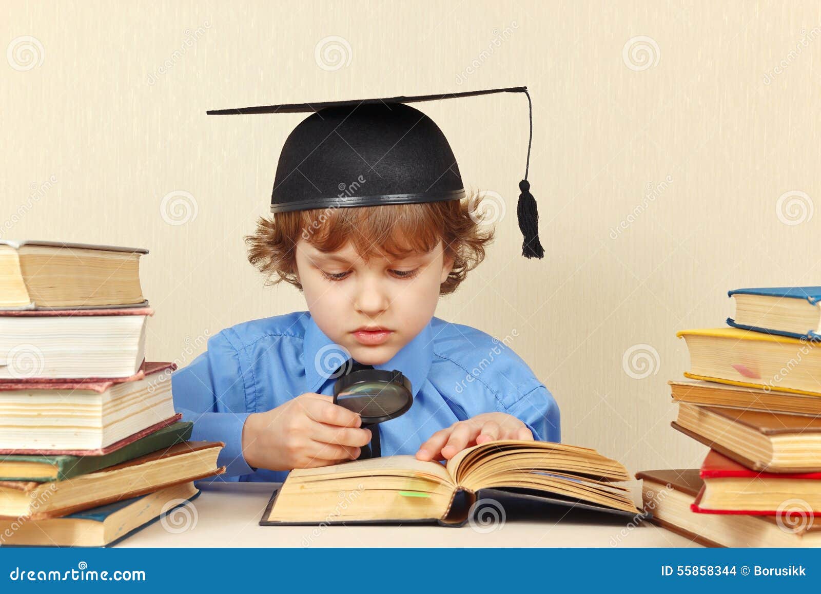 Little Serious Boy in Academic Hat Studies an Old Books with Magnifying ...