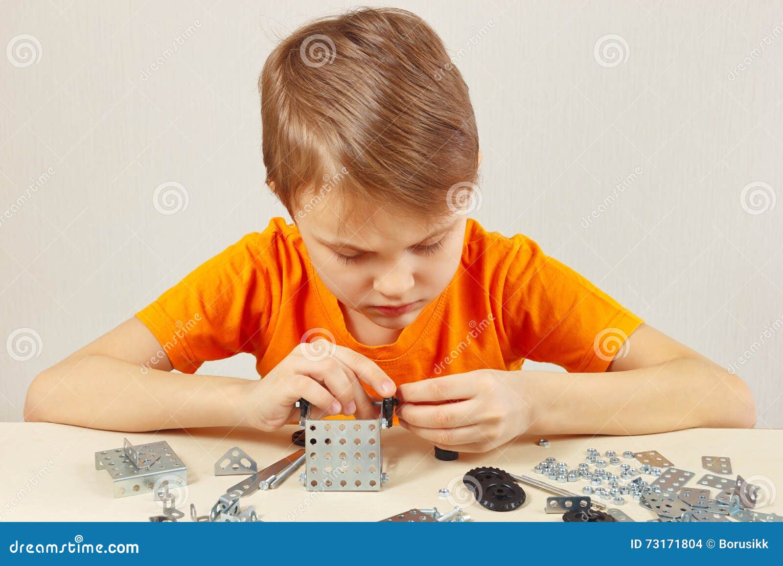 Little Serious Engineer Plays with Mechanical Starter Kit at Table ...