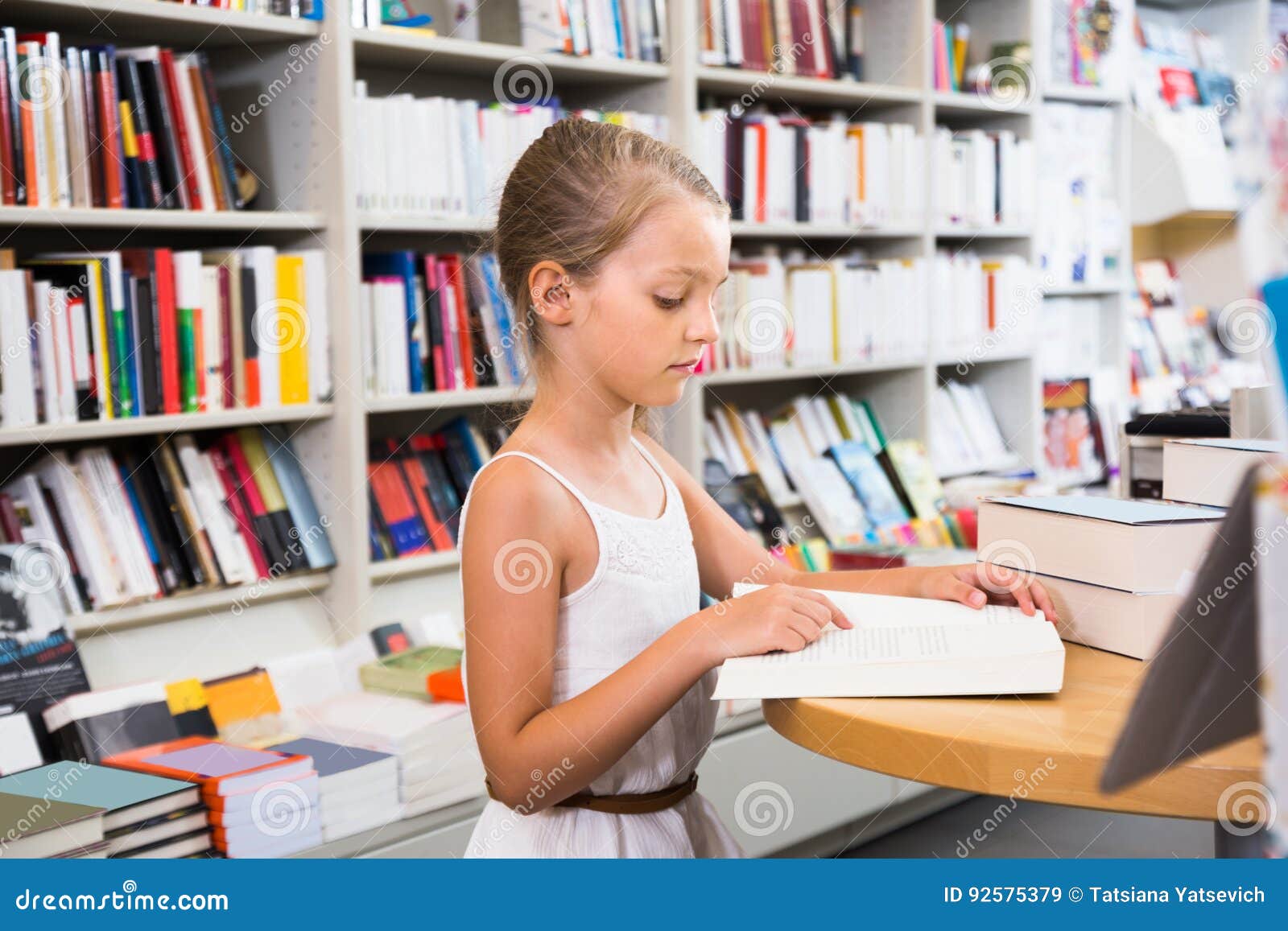 Little Smart Girl Reading a Book in School Library Stock Image - Image ...