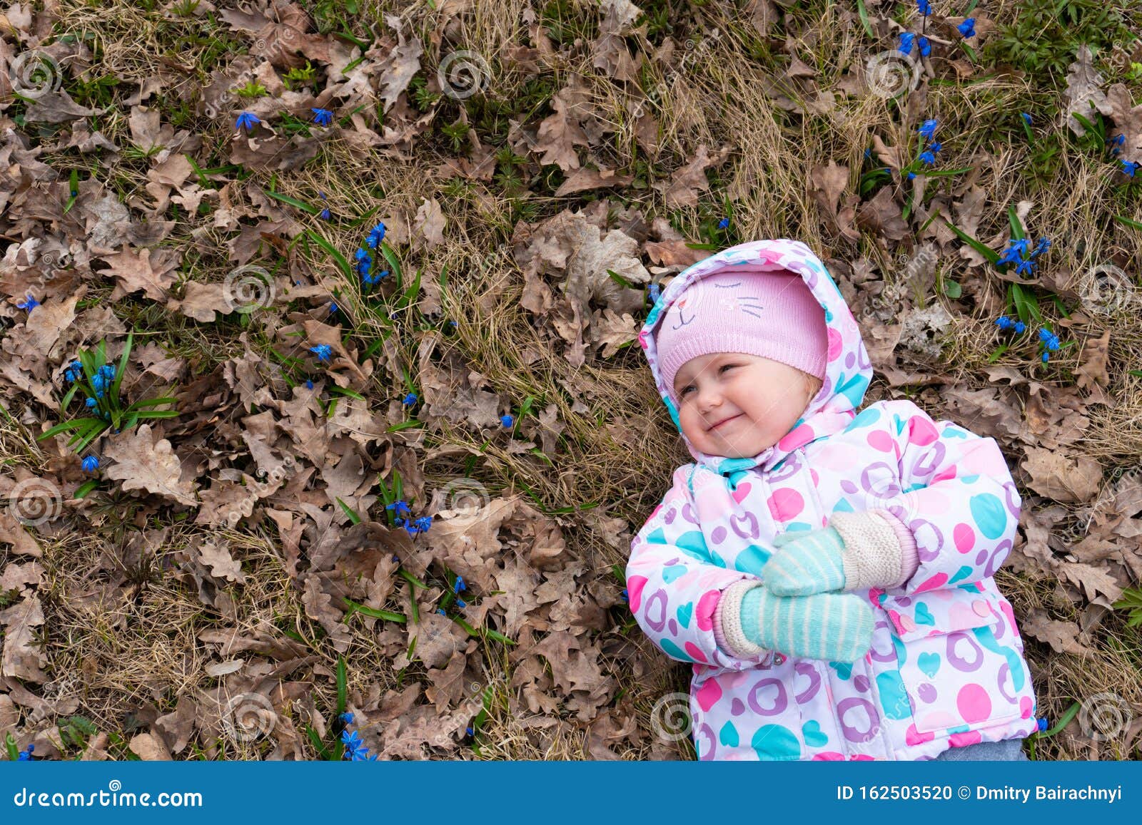 Little Smiling Girl Lying Down in the Field of Snowdrop Flowers Stock ...