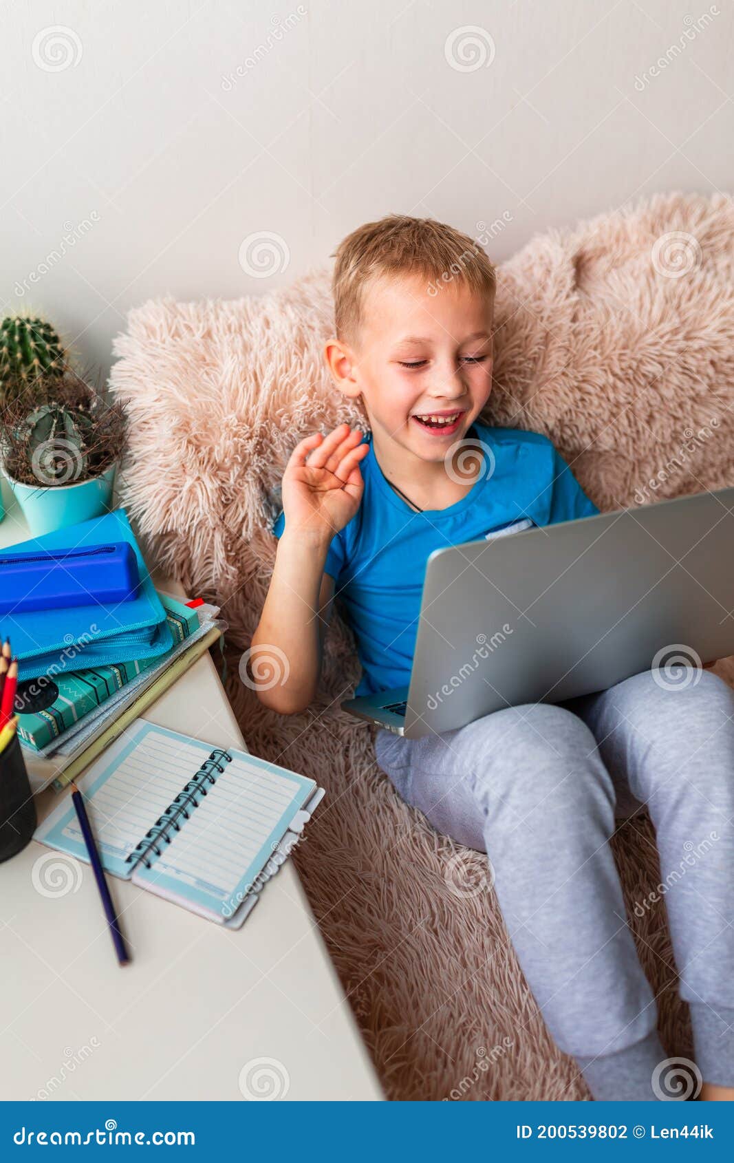 Little Young School Boy Working at Home with a Laptop and Class Notes ...