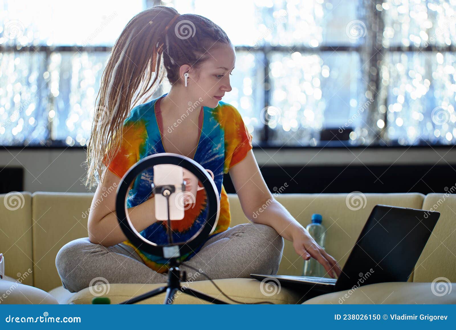 Live Streaming by Woman with Dreadlocks Using Laptop and Ring Light ...