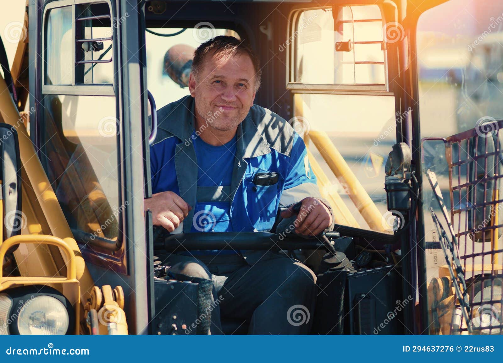 Loader Driver Looks at Camera from Tractor Cab and Smiles. Portrait of ...