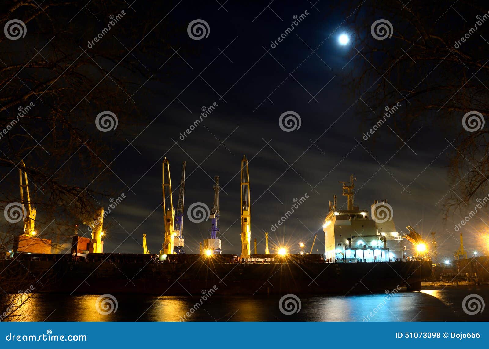 The Loading Cargo Ship with Cranes is Moored in Port at Night Stock ...