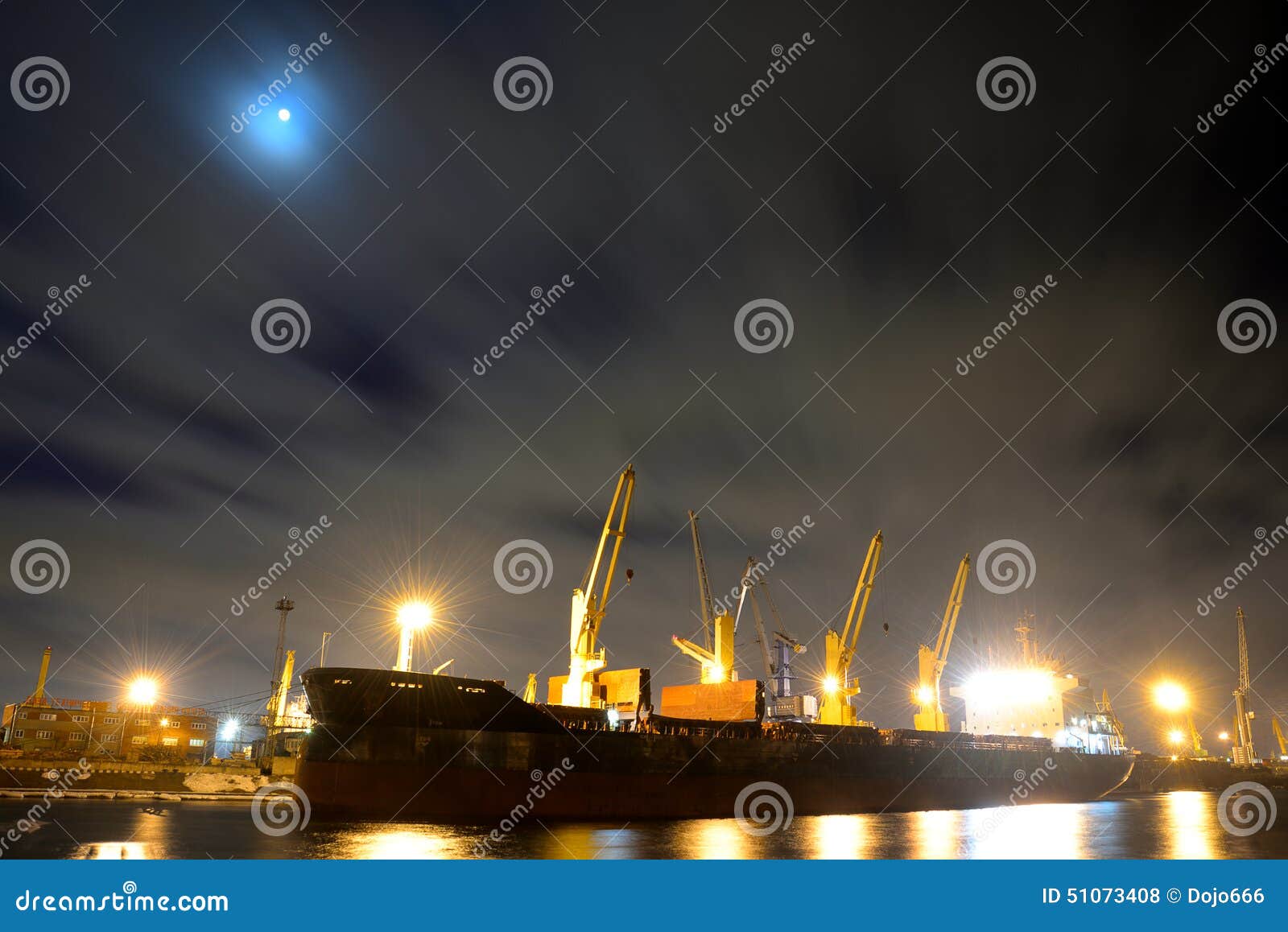 The Loading Cargo Ship with Cranes is Moored in Port at Night Stock ...