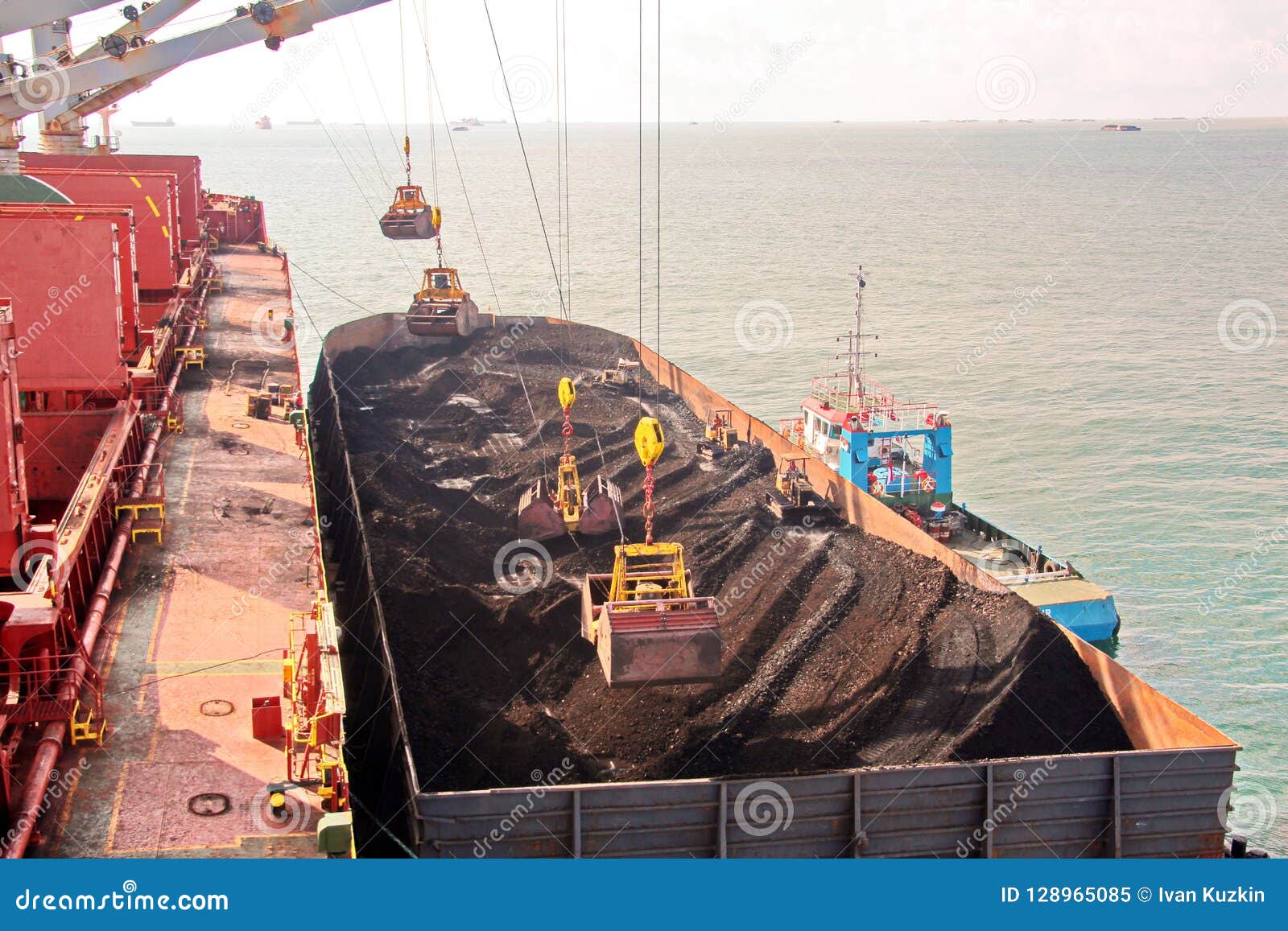 Loading Coal from Cargo Barges Onto a Bulk Carrier Using Ship Cranes ...