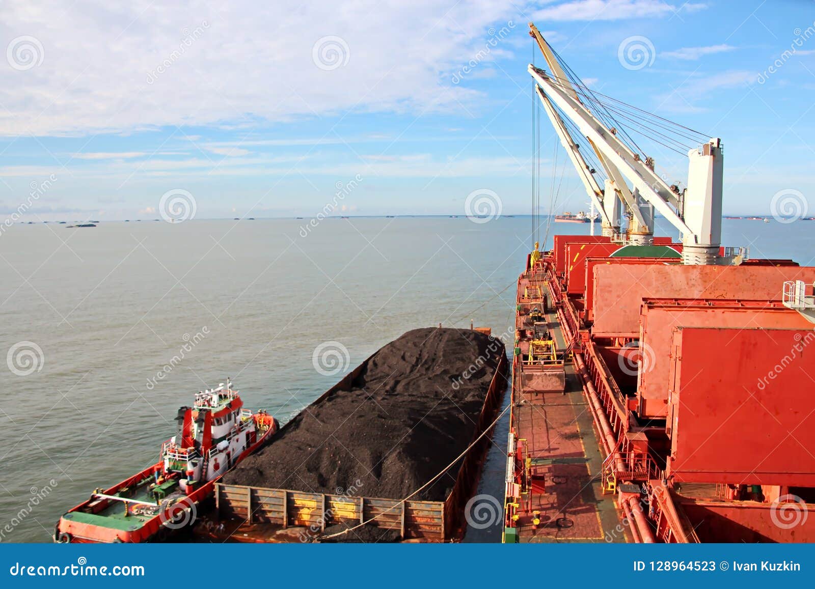 Loading Coal from Cargo Barges Onto a Bulk Carrier Using Ship Cranes ...