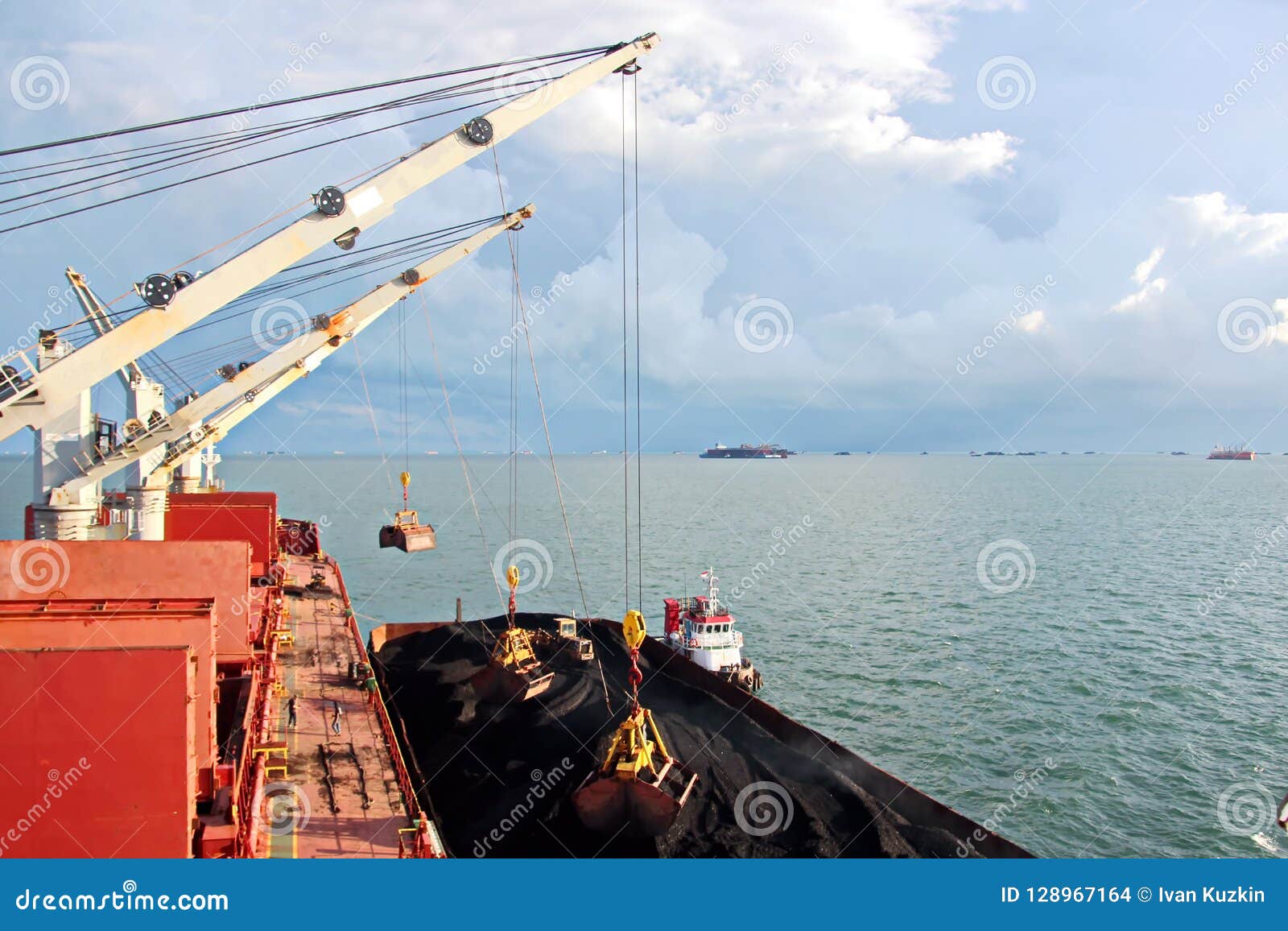 Loading Coal from Cargo Barges Onto a Bulk Carrier Using Ship Cranes ...