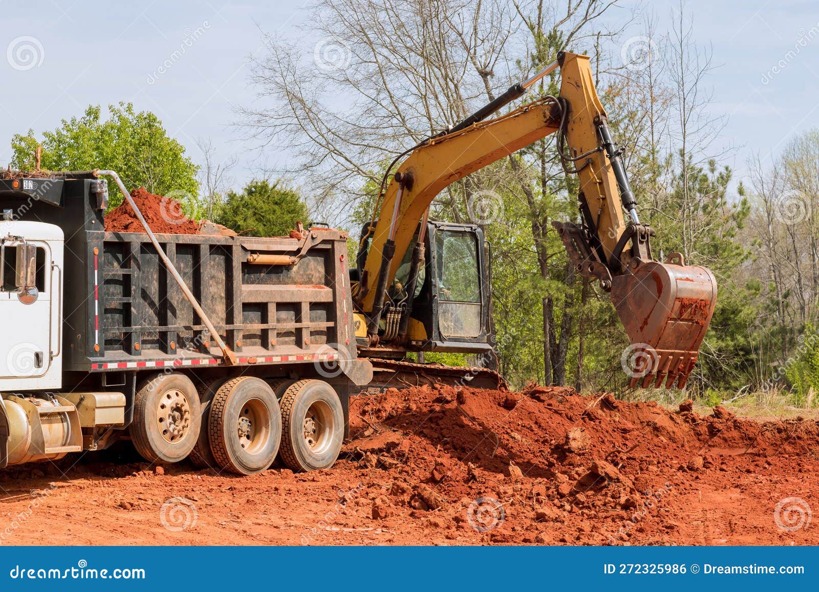 Loading Earth into a Dump Truck on a Construction Site with an ...