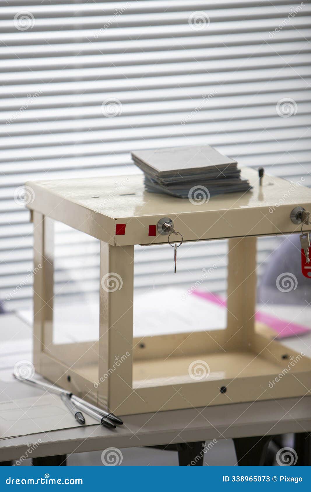 A Locked Transparent Ballot Box with a Stack of Blue Envelopes on Top ...